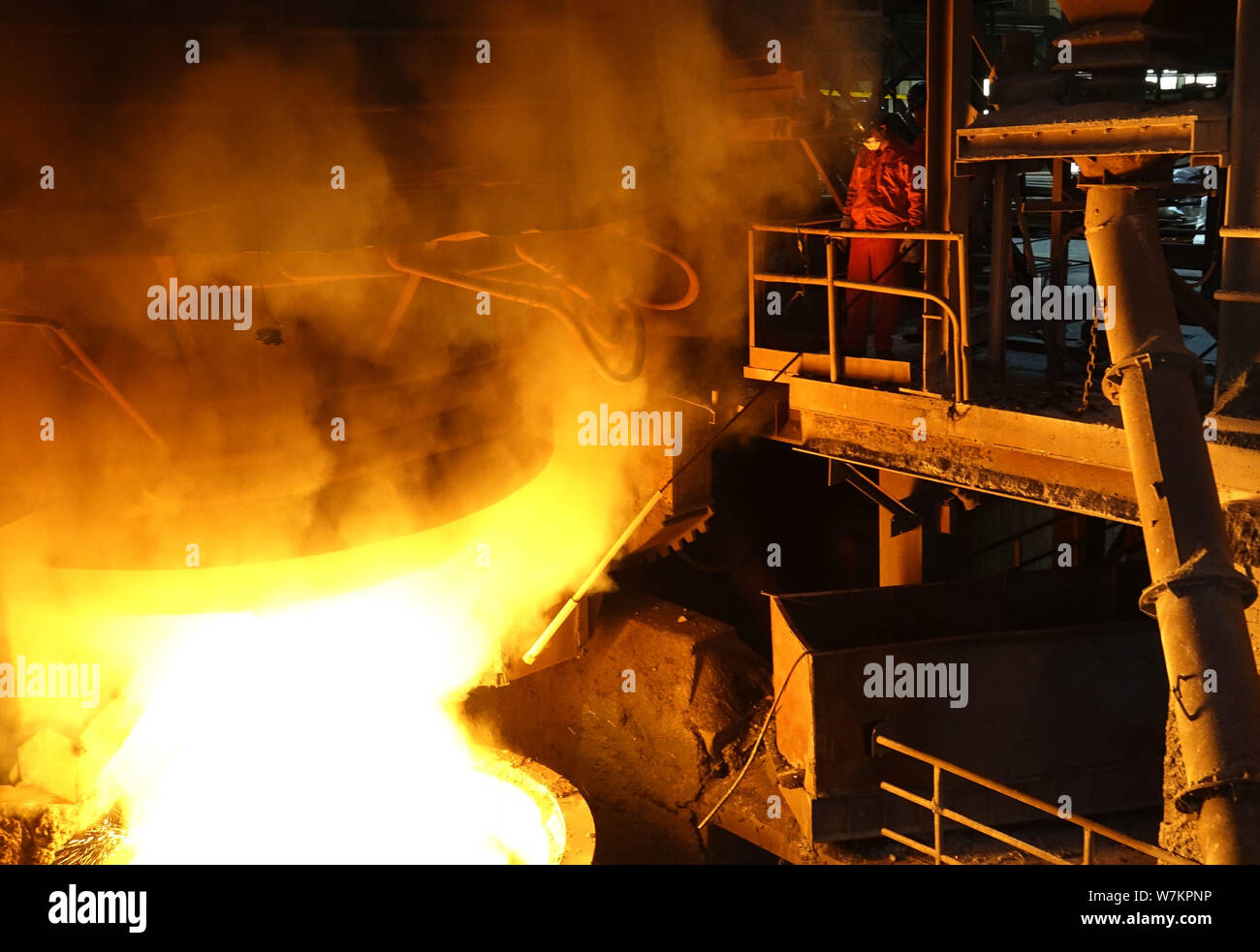 --FILE--A Chinese worker surveys the production of steel next to a ...