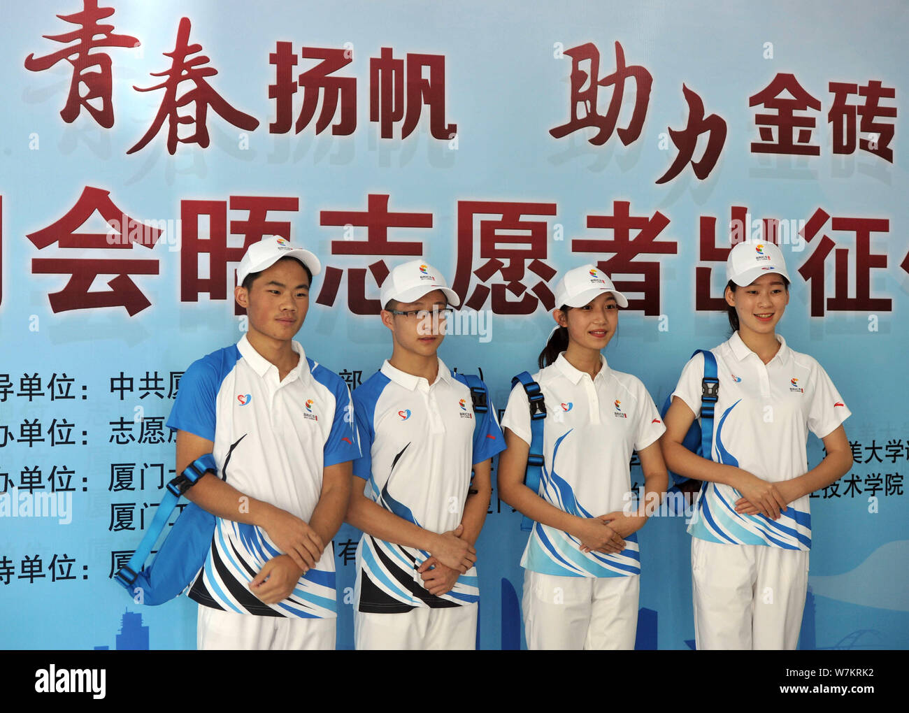 Chinese volunteers dressed in uniforms for the Ninth BRICS Summit pose ...