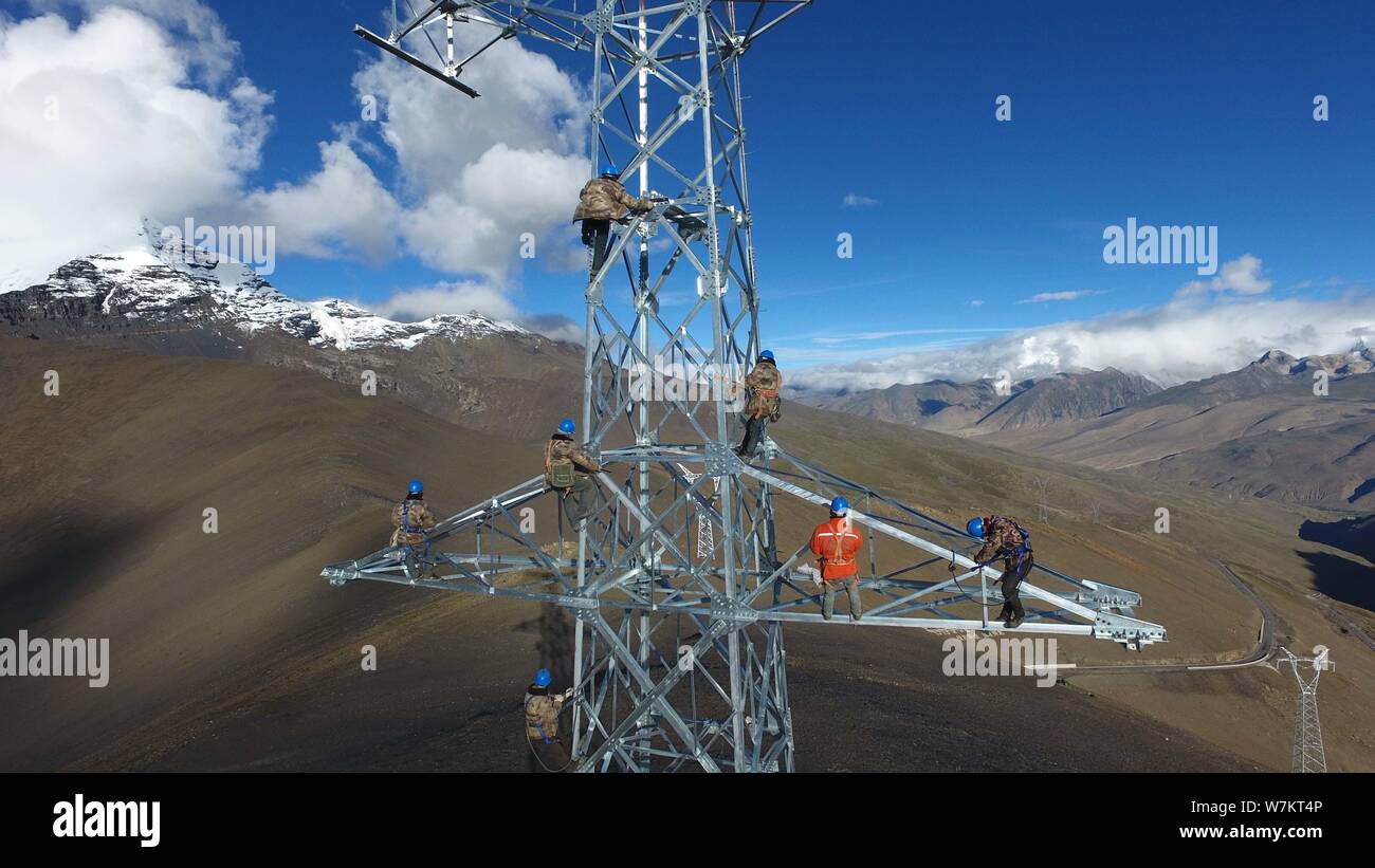 Electricity workers are assembling the highest power transmission tower in the world with a ...