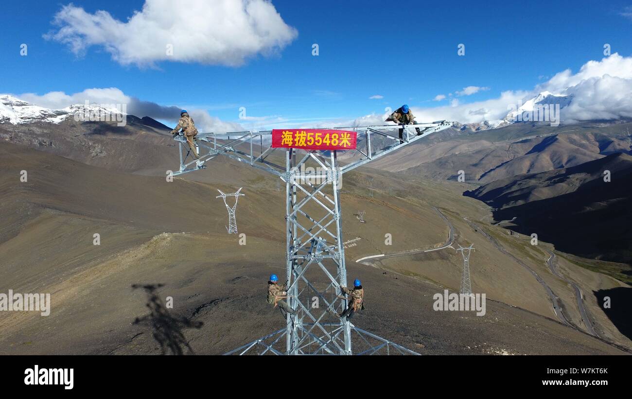 Electricity workers are assembling the highest power transmission tower in the world with a ...