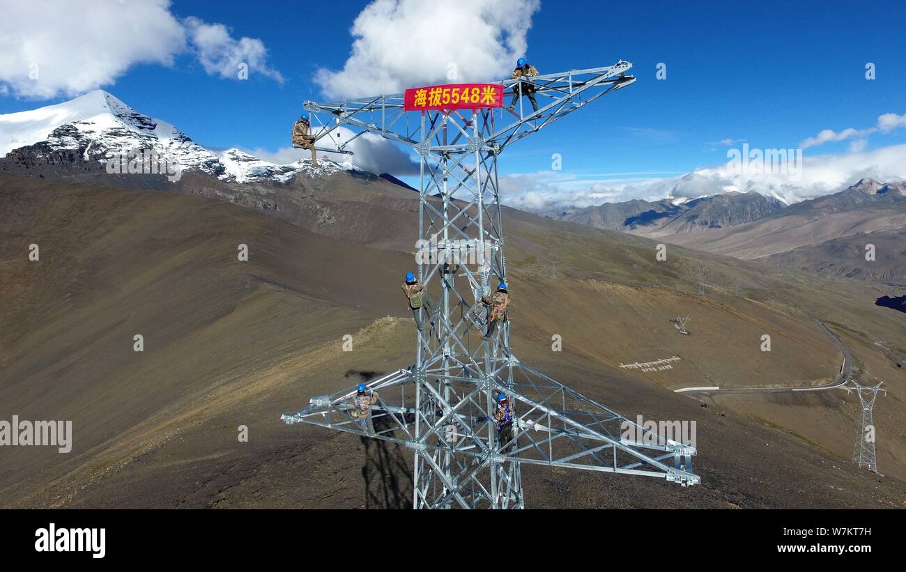 Electricity workers are assembling the highest power transmission tower in the world with a ...