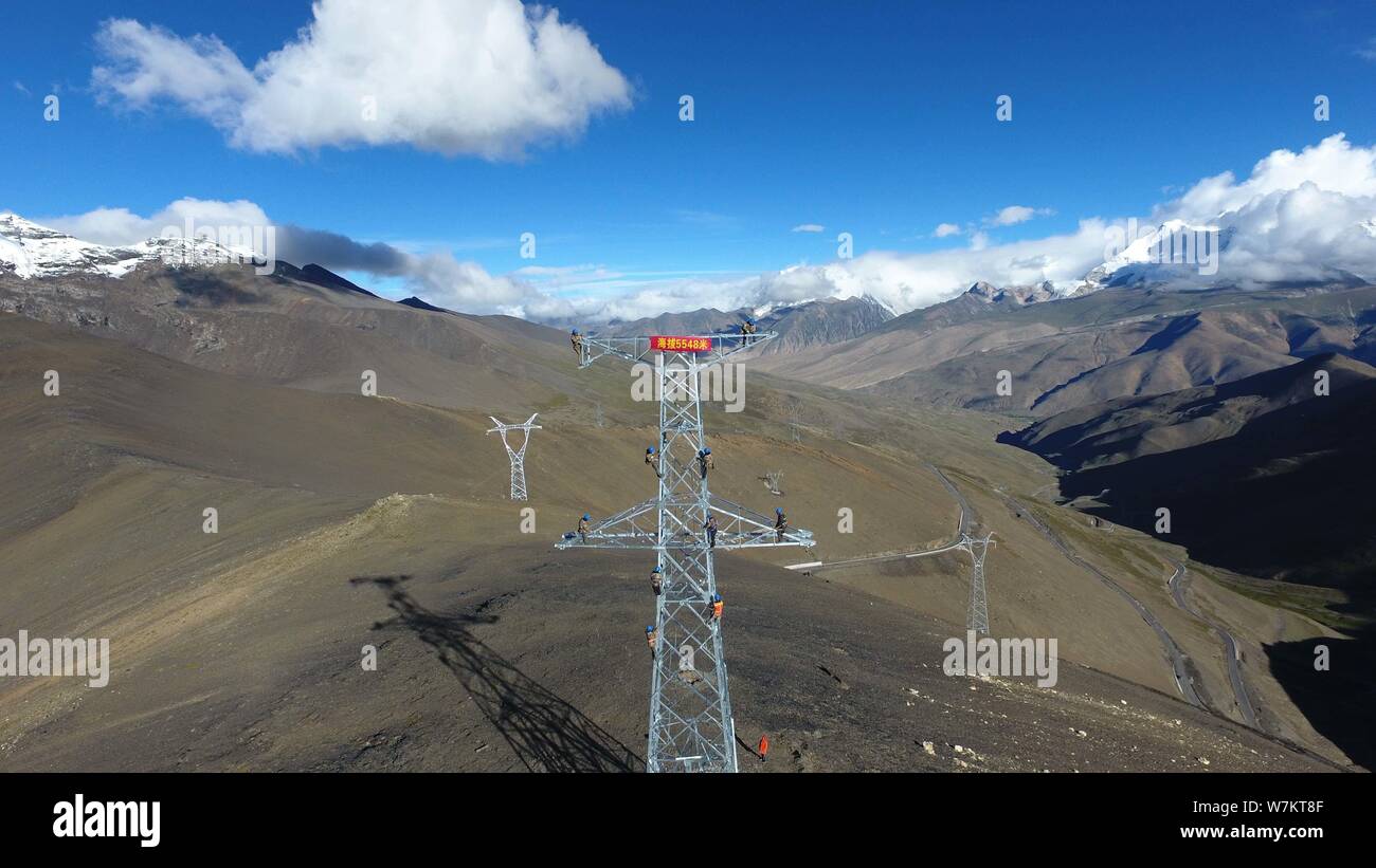 Electricity workers are assembling the highest power transmission tower in the world with a ...