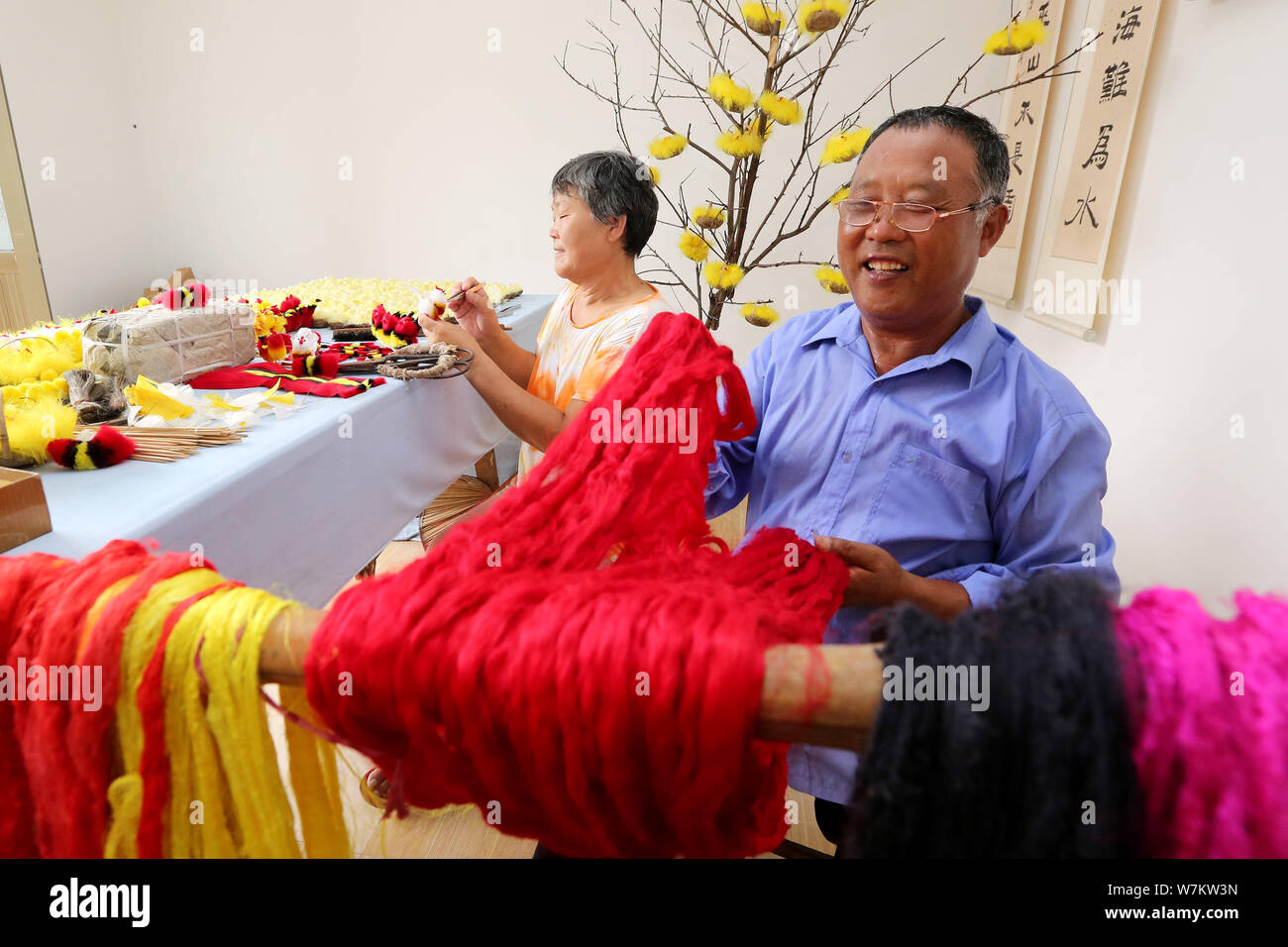 Chinese craftsman Cui Yongxin makes velvet roosters with his wife at ...