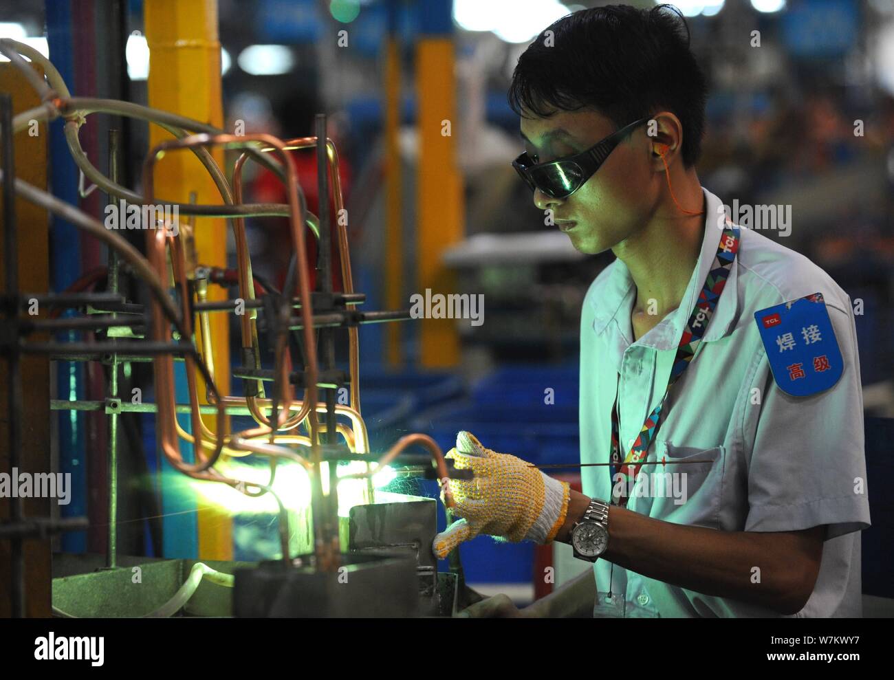 --FILE--A Chinese worker welds parts for air-conditioners on the ...