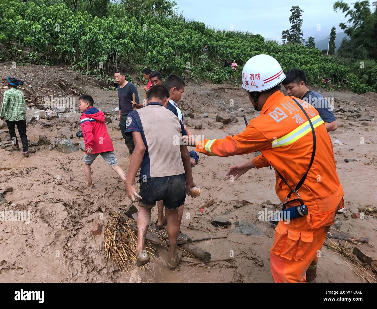 A Chinese rescuer evacuates local villagers from the debris of a ...