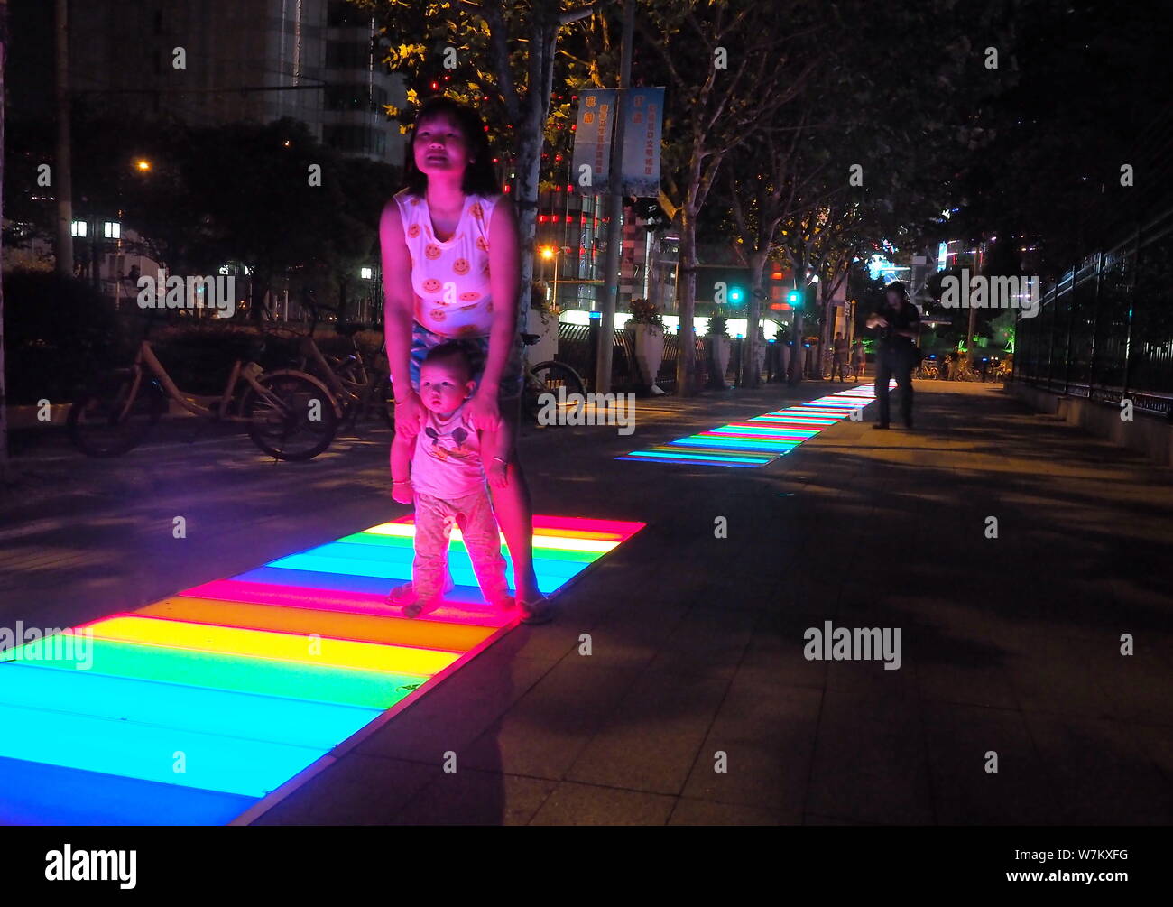 Local residents walk on the promenade featuring colourful LED lights in ...