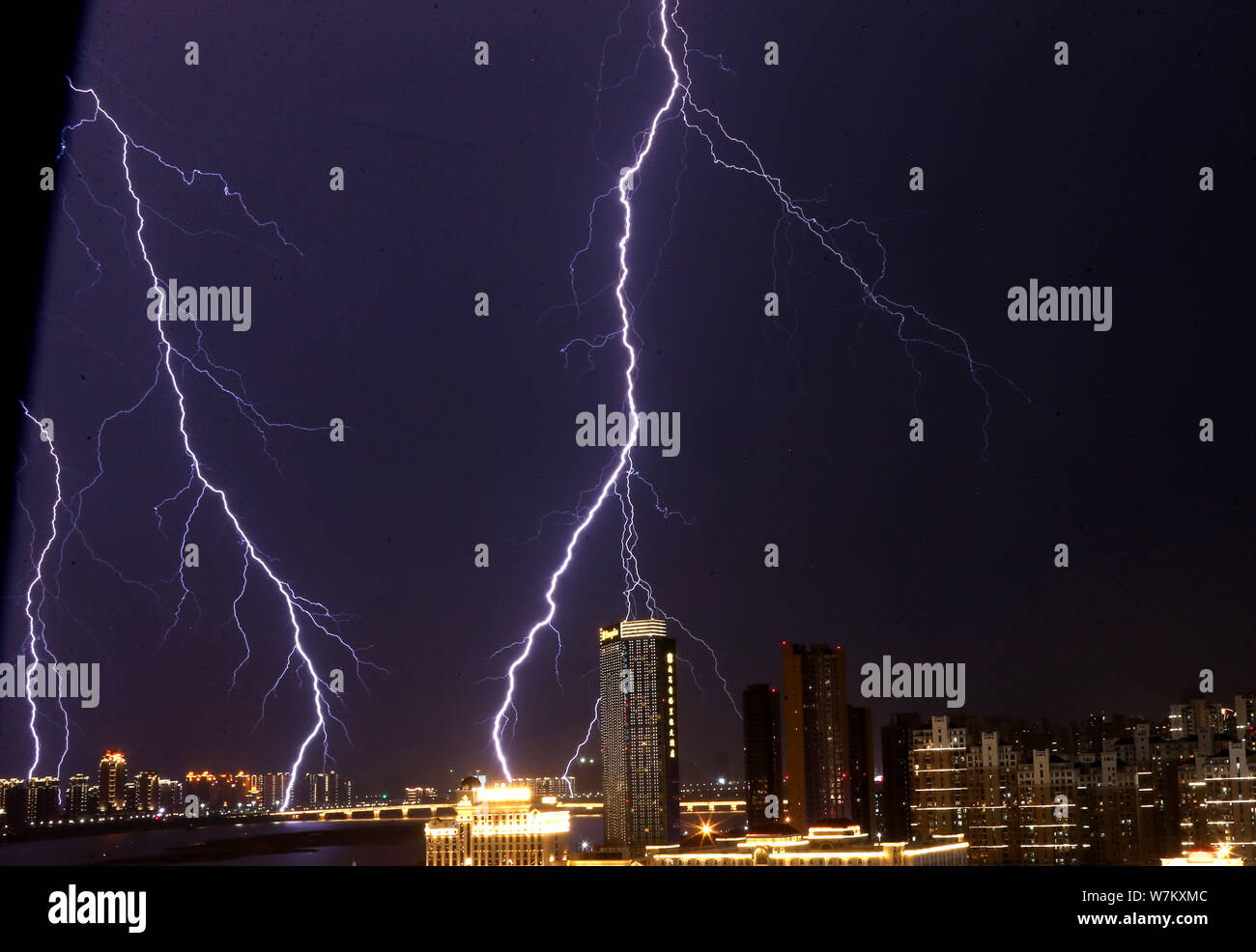 View of lightning strikes three times simultaneously in the night sky ...