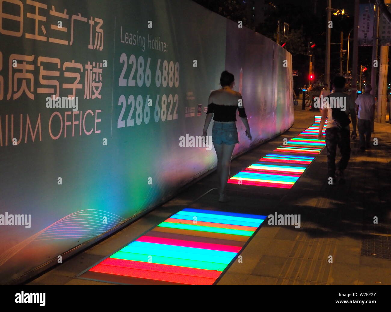 A local resident walks on the promenade featuring colourful LED lights ...