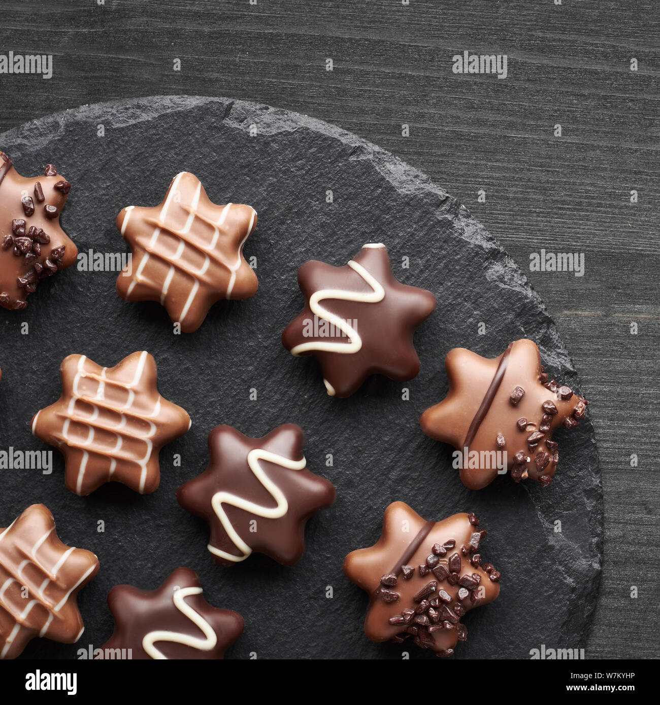 Star-shaped chocolates on dark textured background, square composition ...