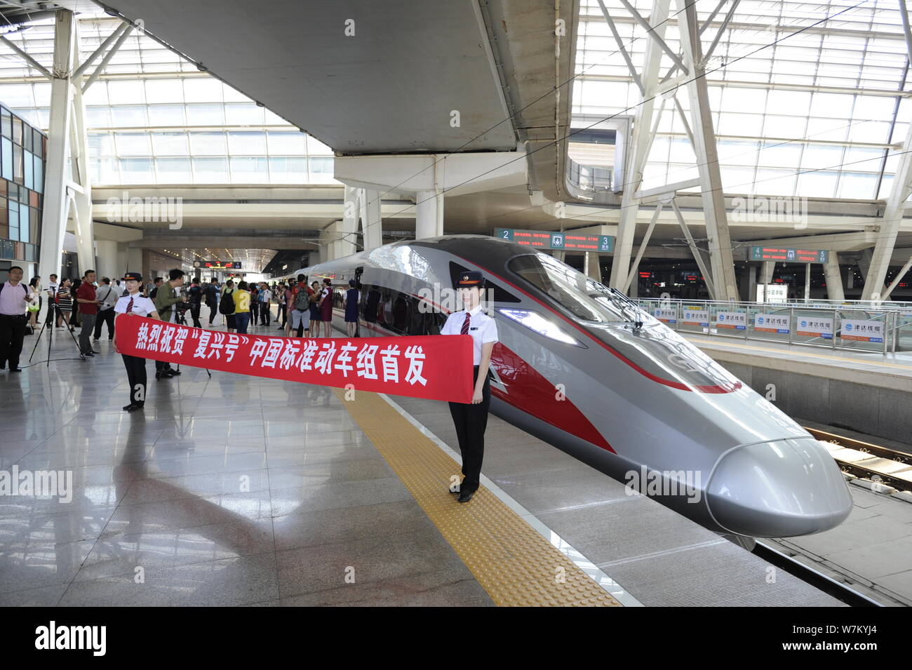 --FILE--Attendants pose in front of a "Fuxing" high speed bullet train ...