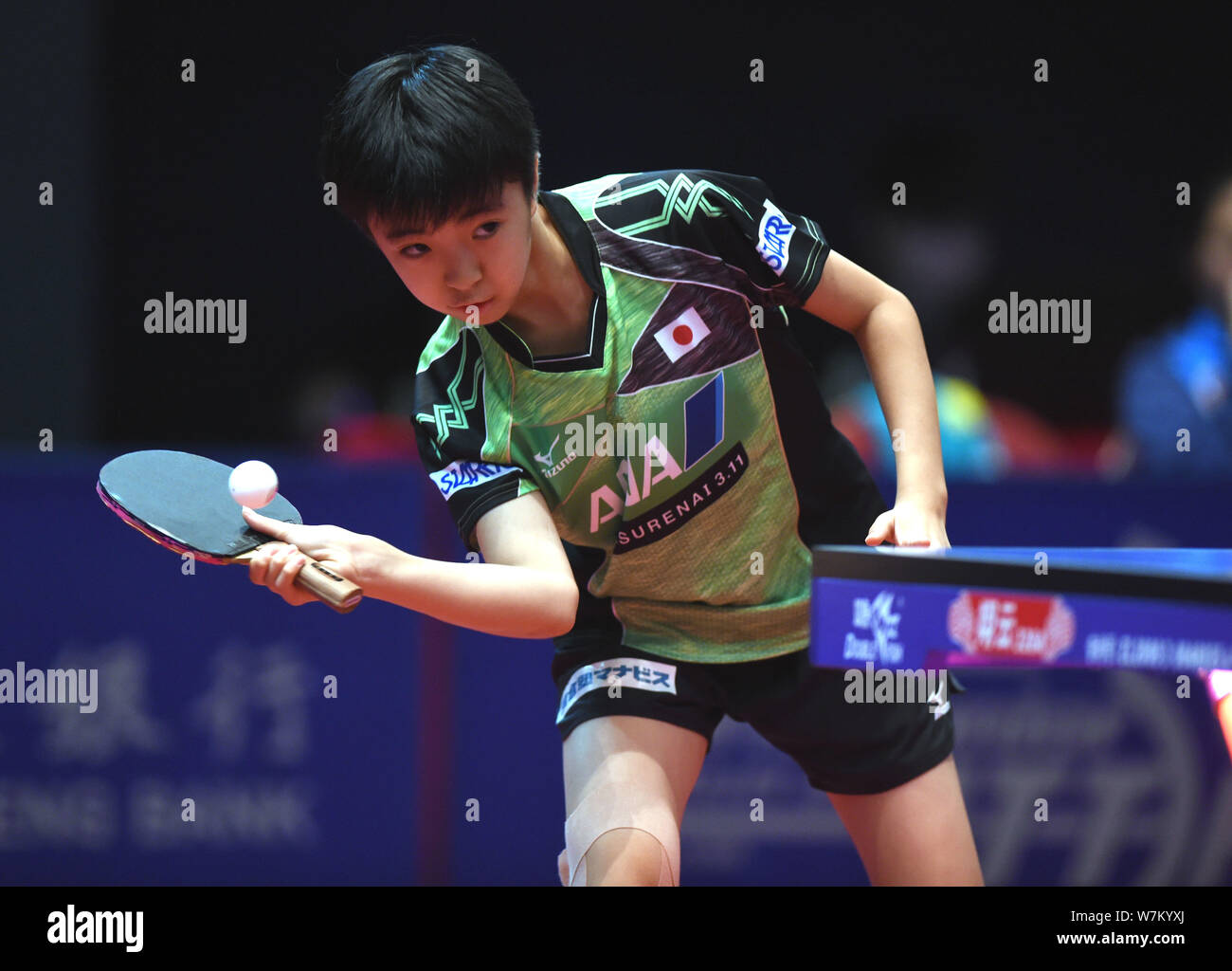 Ojio Haruna of Japan returns a shot as she and Yumoto Fuwa compete ...
