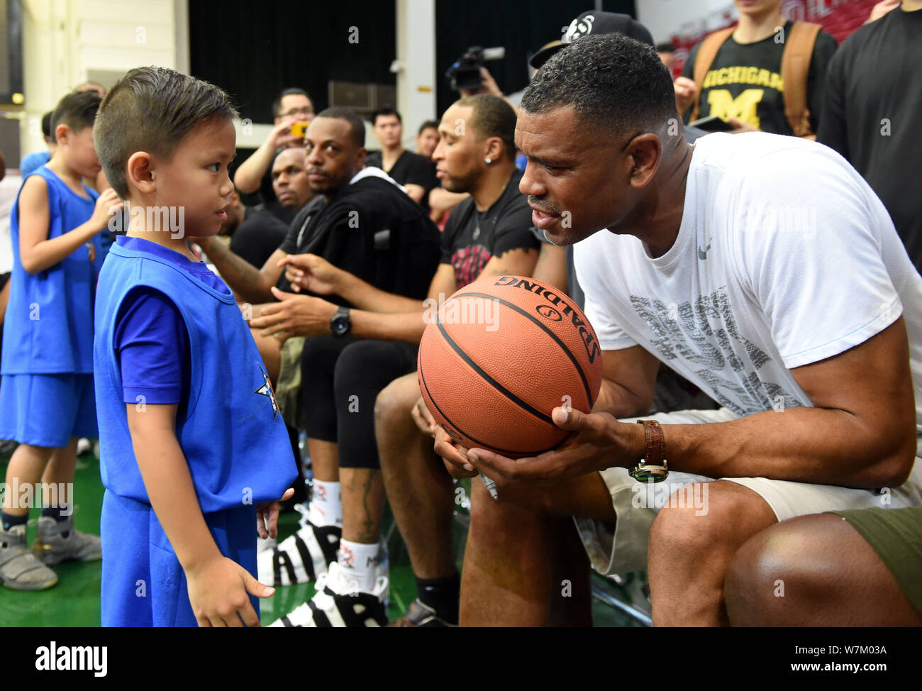 NBA star Allan Houston, right, signs for a younger player during a ...