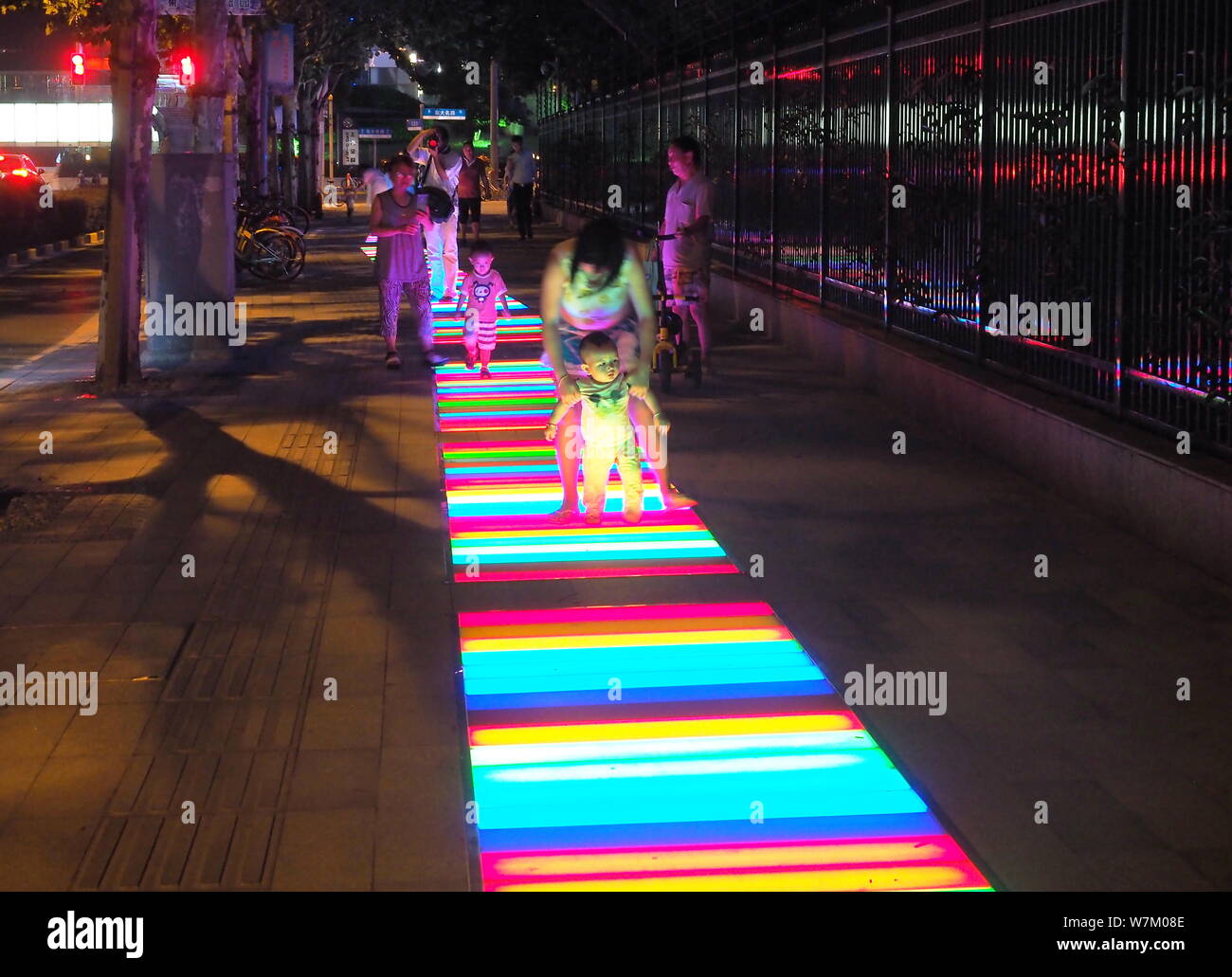 Local residents walk on the promenade featuring colourful LED lights in ...