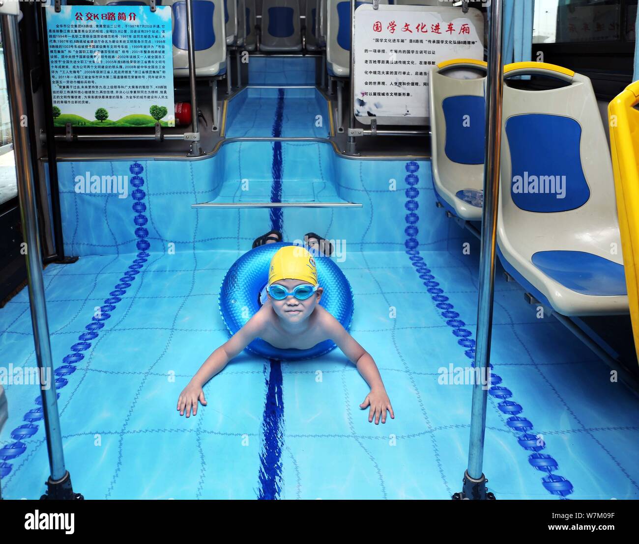 A young Chinese boy dressed in swimwear poses on a swimming pool-themed ...