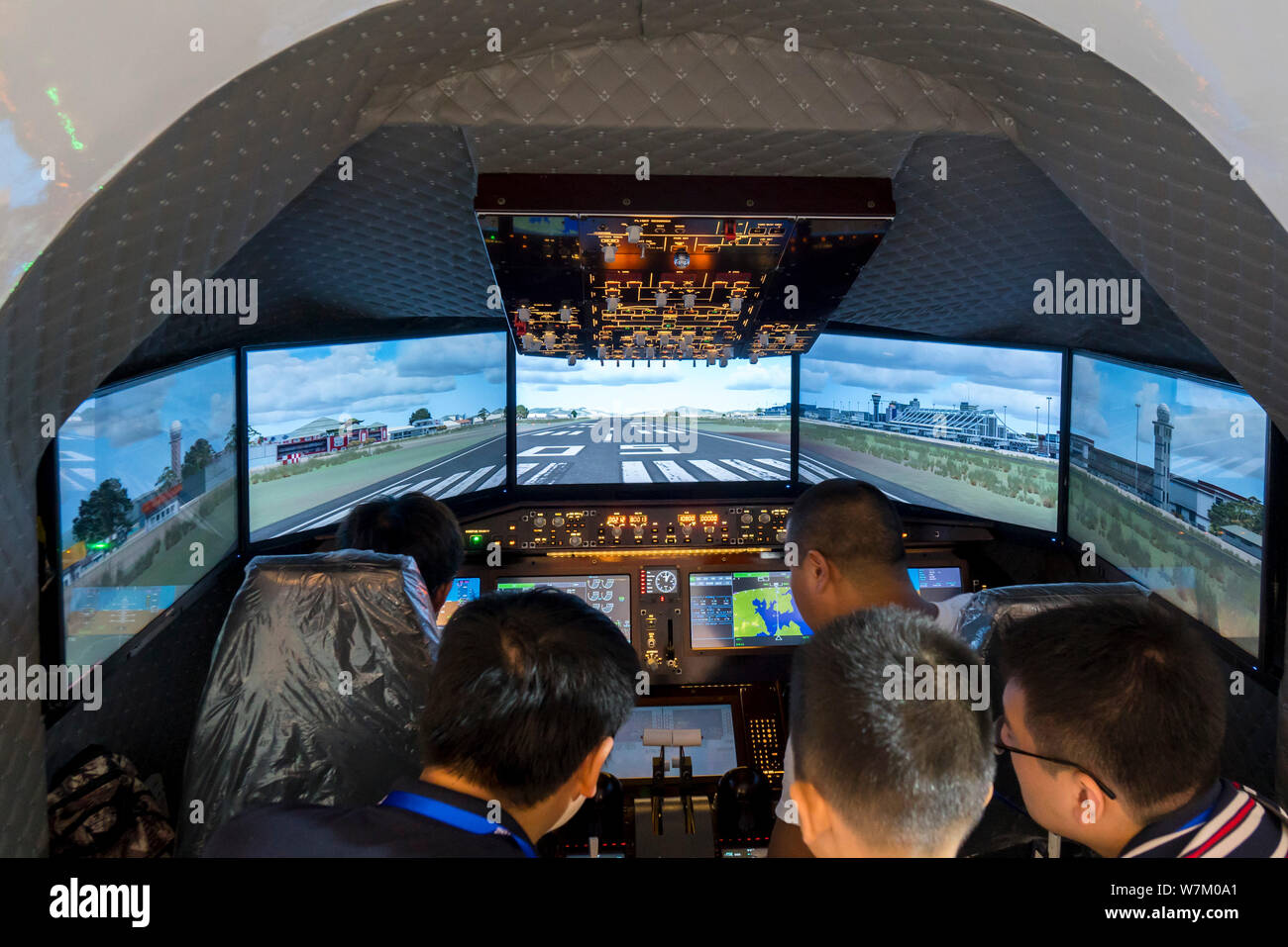 Visitors try out a flight simulator of China's first large passenger ...