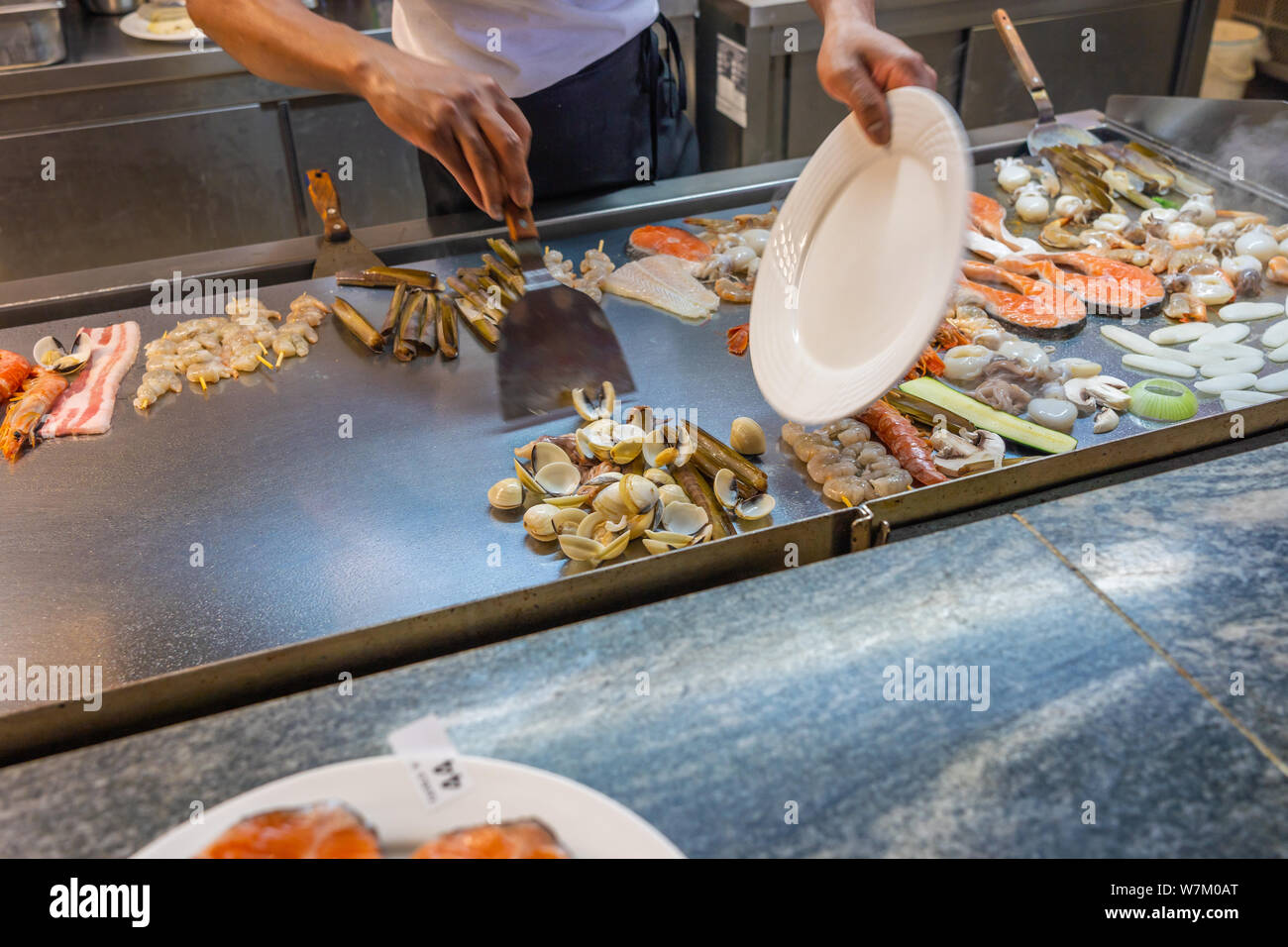 BBQ buffet chef grilling assorted seafood on big pan Stock Photo - Alamy