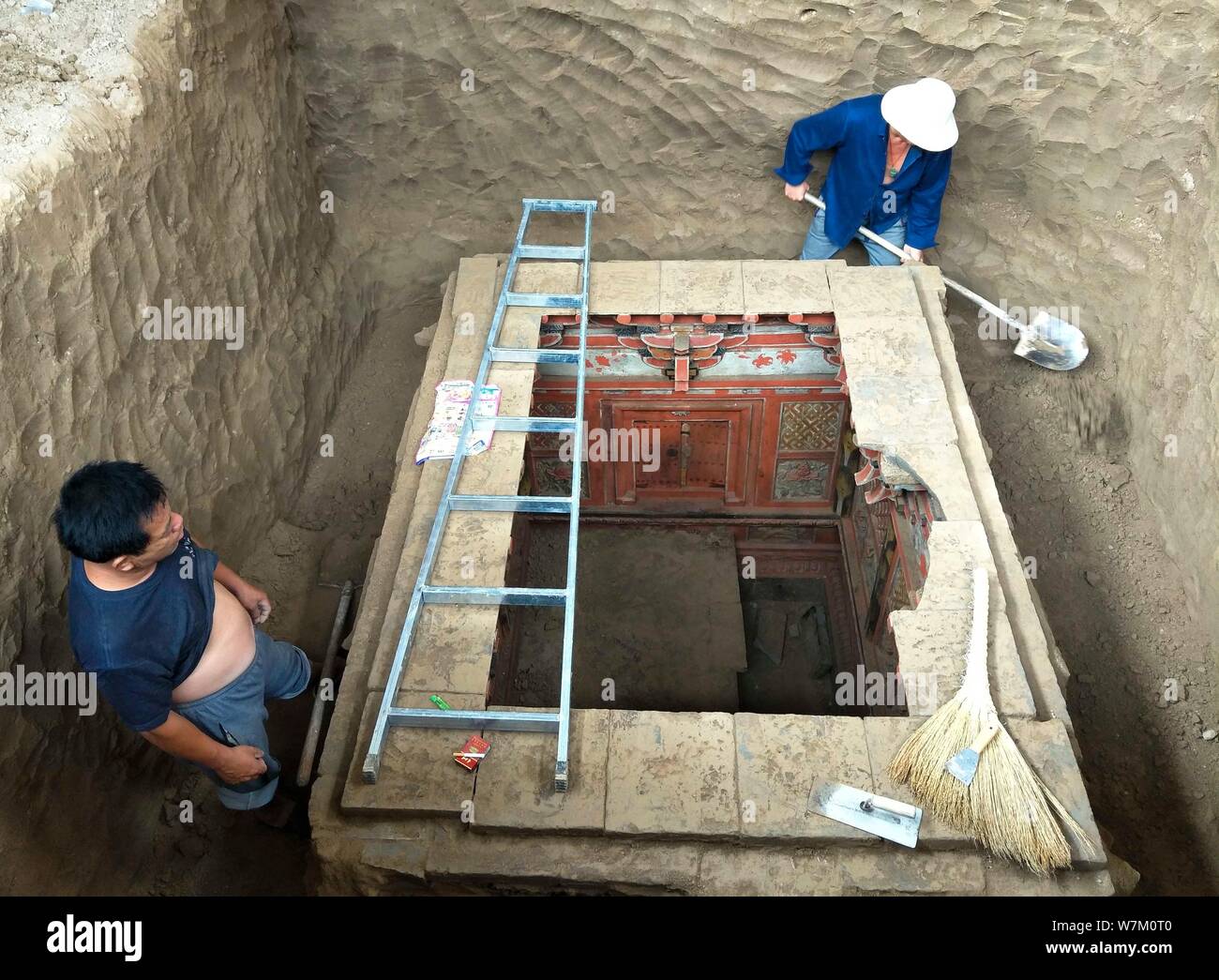 Chinese workers excavate a square-shaped tomb dating back to the period ...