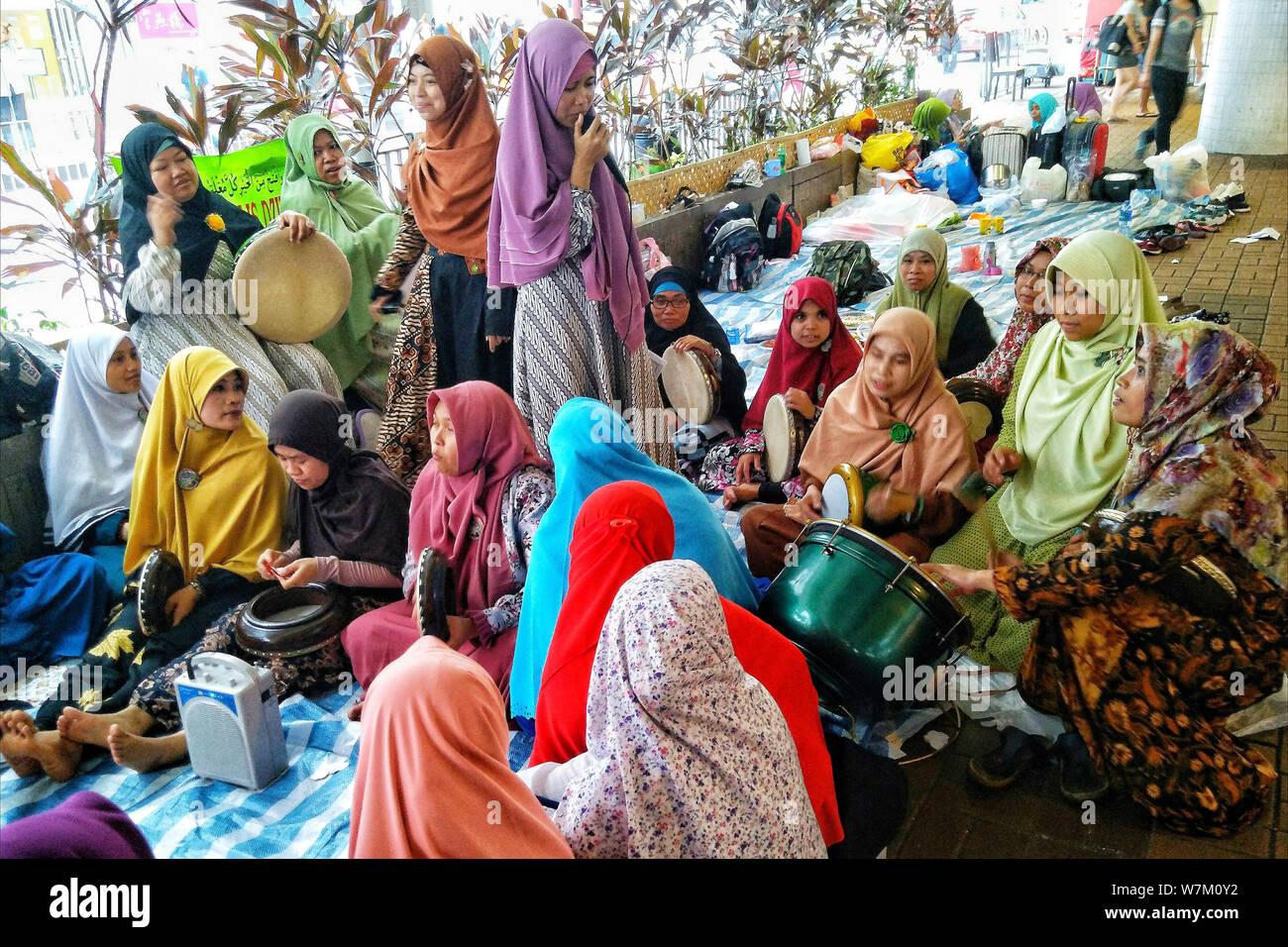 --FILE--Filipino maids sing during a weekend gathering under a ...