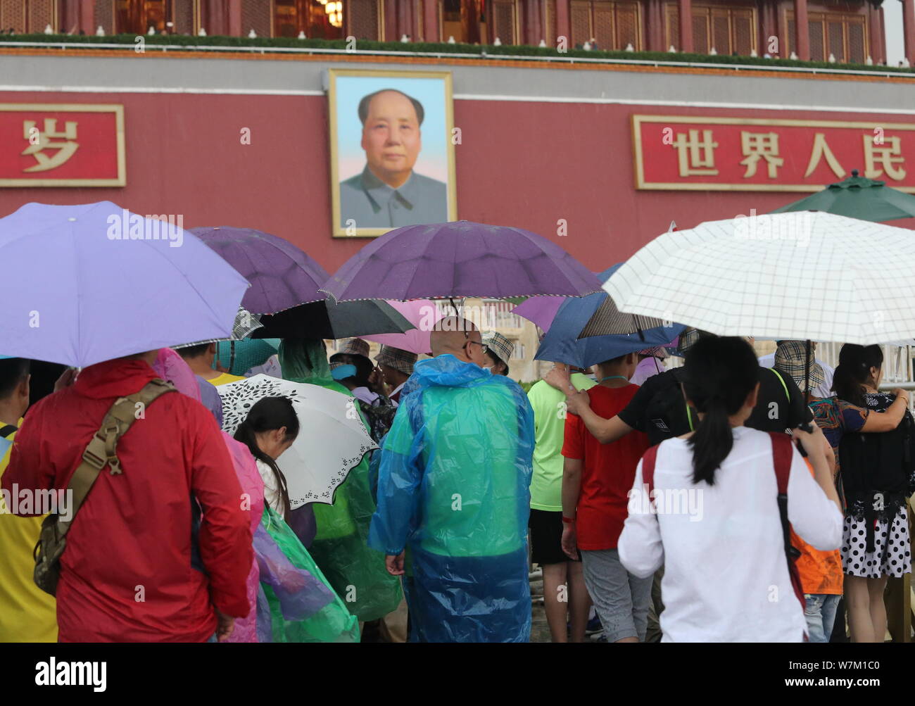 Tourists in rain coats and with umbrellas are pictured in heavy rain on ...