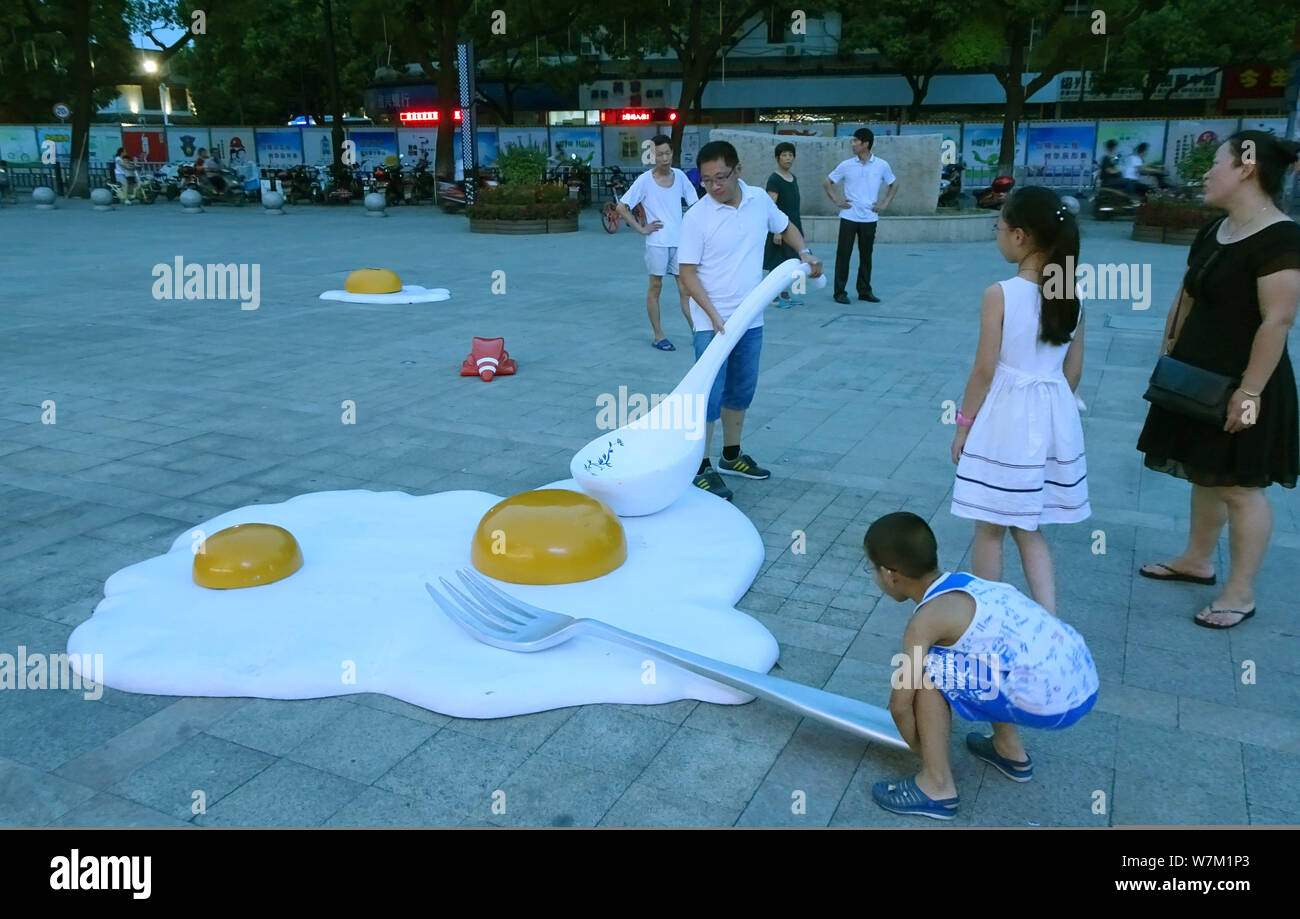 Local residents pose for photos with giant artworks featuring the shape ...