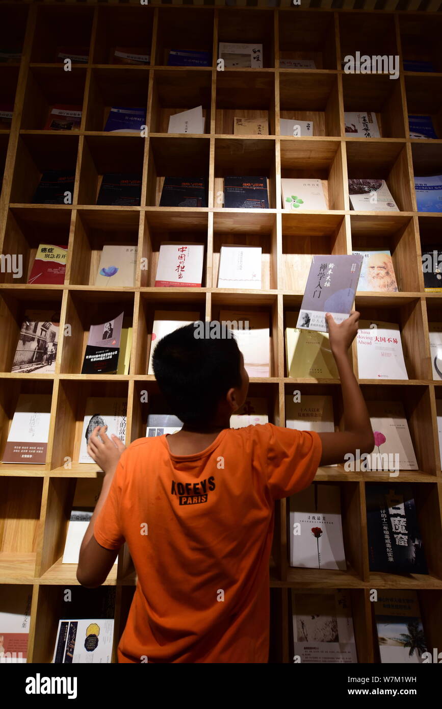 A customer takes a book off the shelves at a shared book store in ...