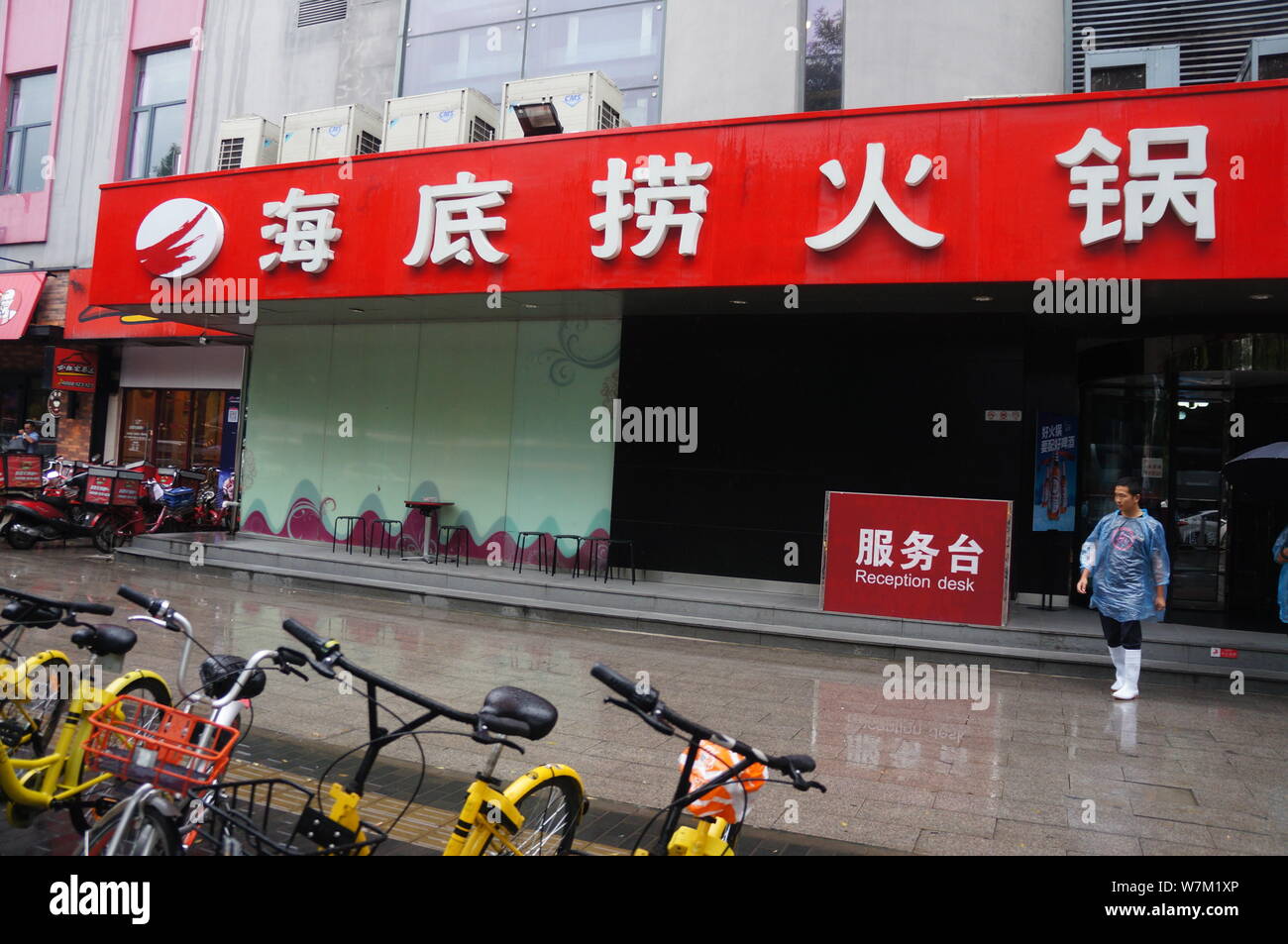 Chinese employees are seen in front of a restaurant of Hai Di Lao ...