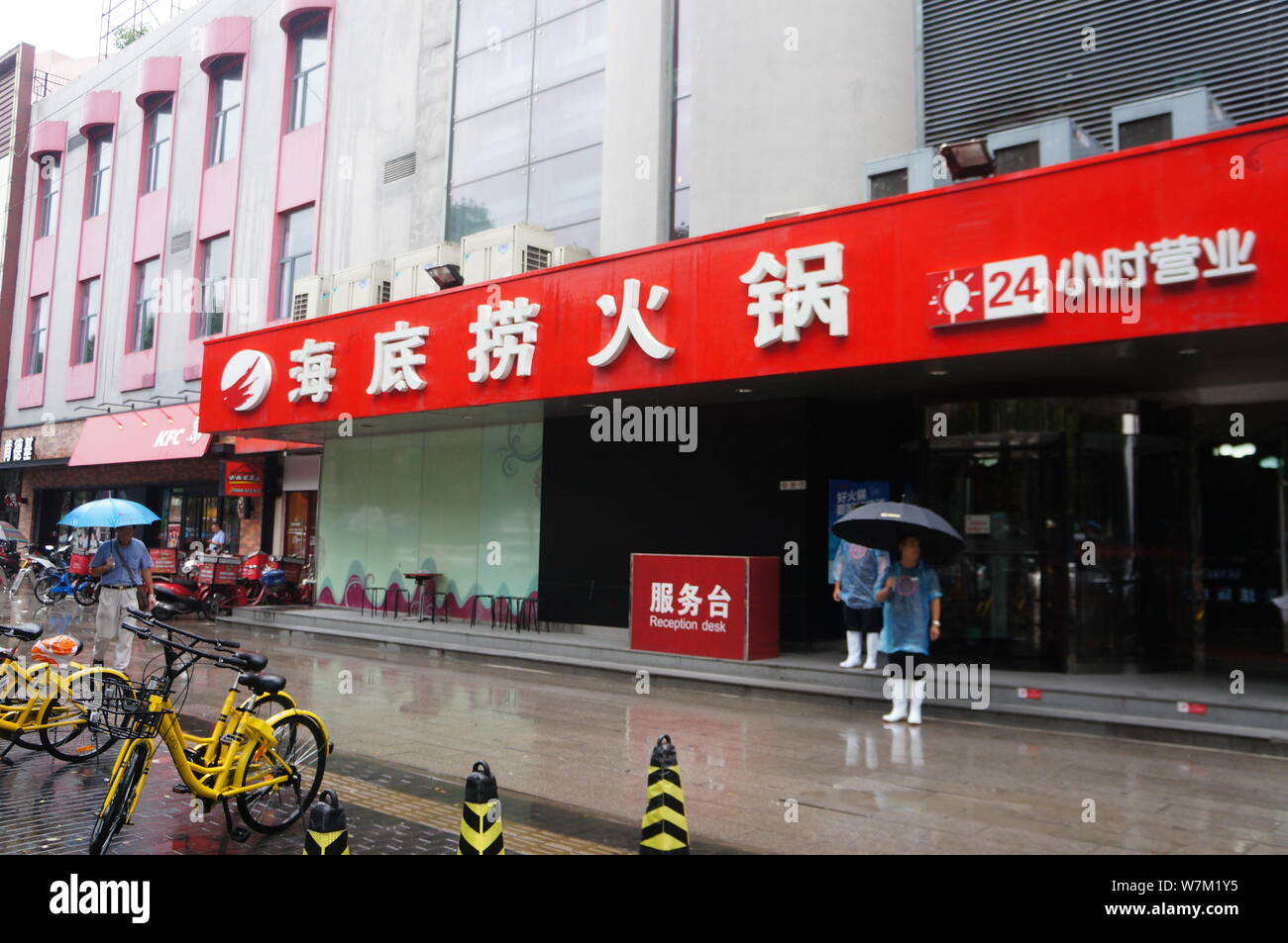 Chinese employees are seen in front of a restaurant of Hai Di Lao ...
