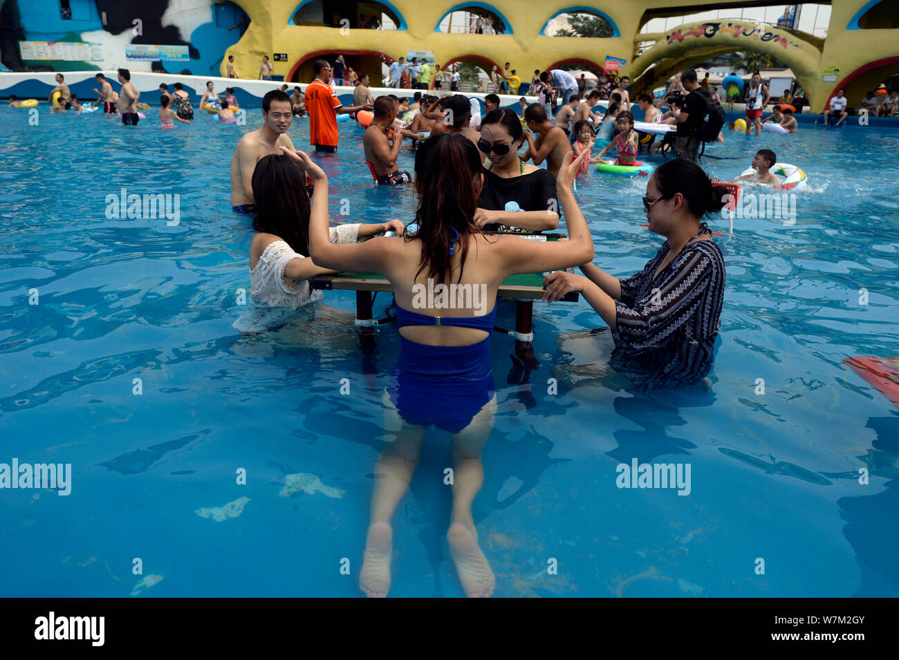 Chinese holidaymakers play mahjong in the water at a water park in ...