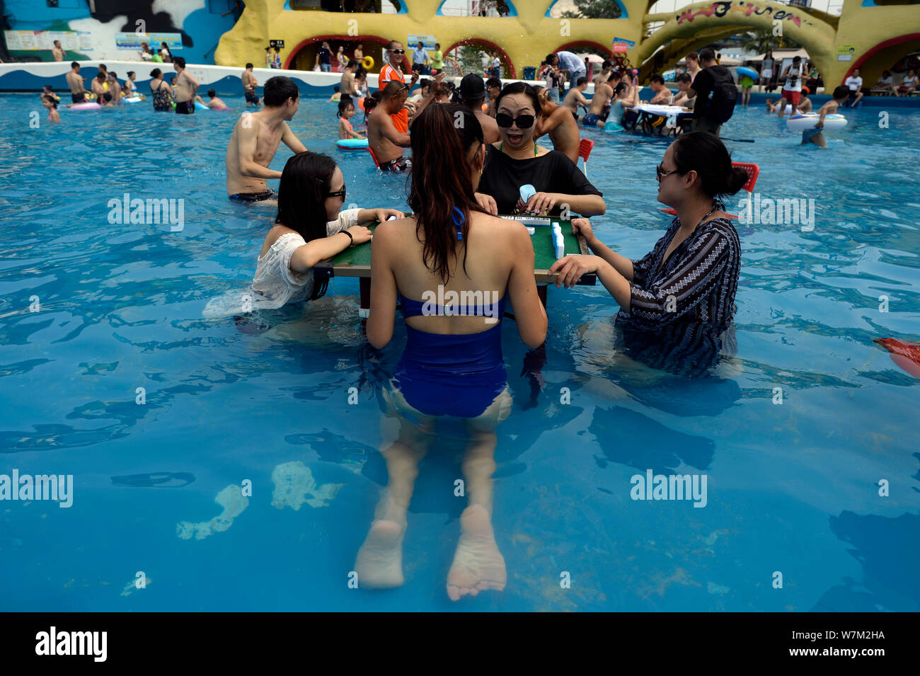 Chinese holidaymakers play mahjong in the water at a water park in ...