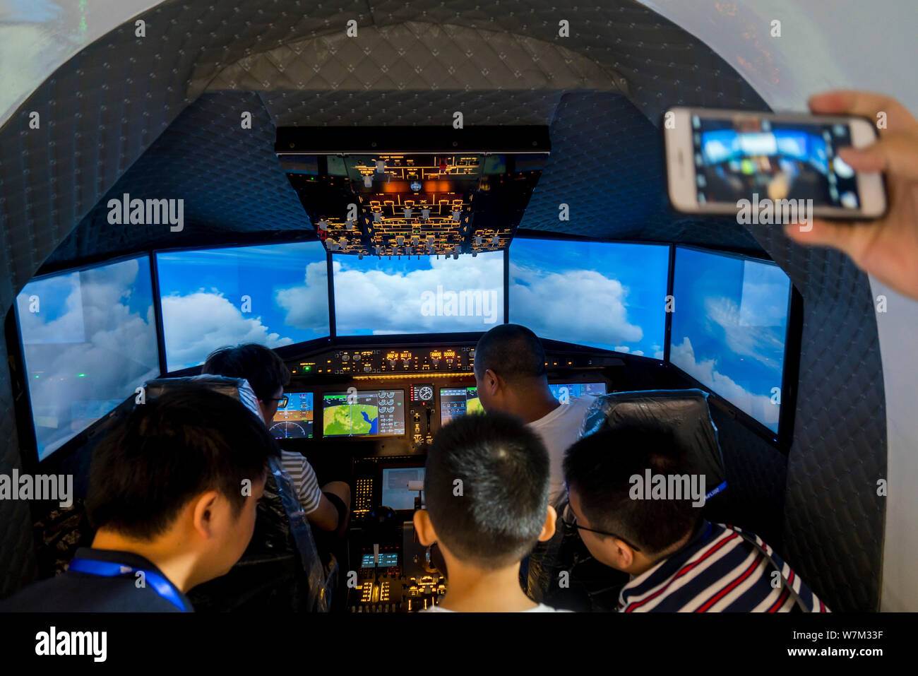 Visitors try out a flight simulator of China's first large passenger ...