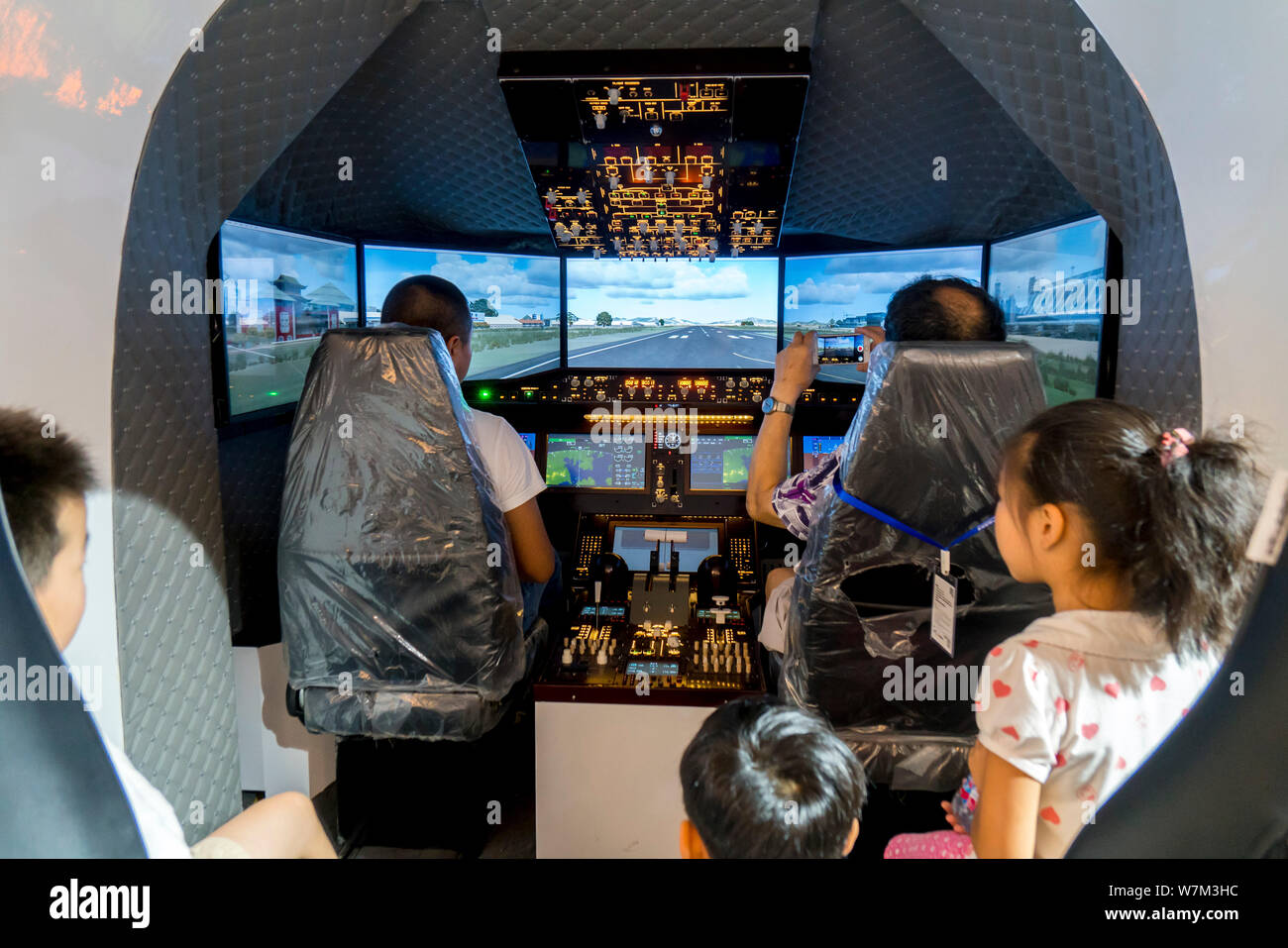 Visitors try out a flight simulator of China's first large passenger ...