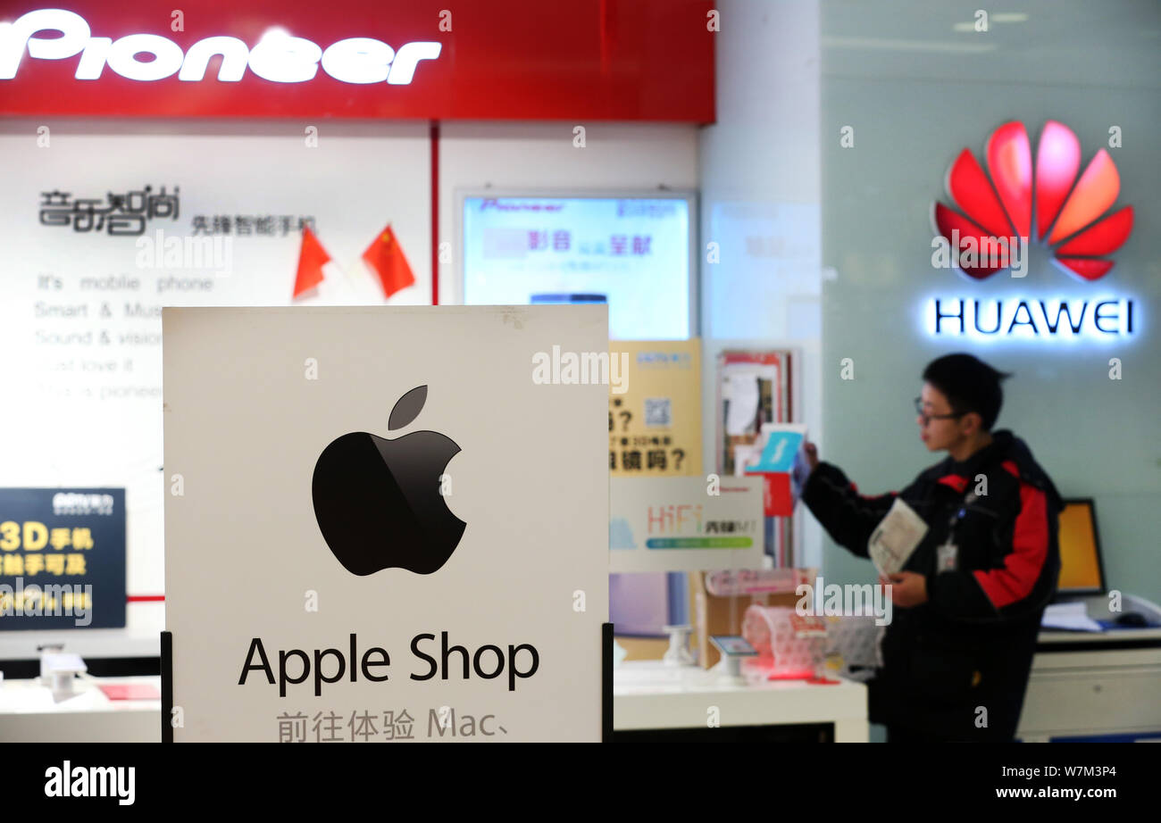 --FILE--A logo of Apple is pictured in front of the counter of Huawei ...