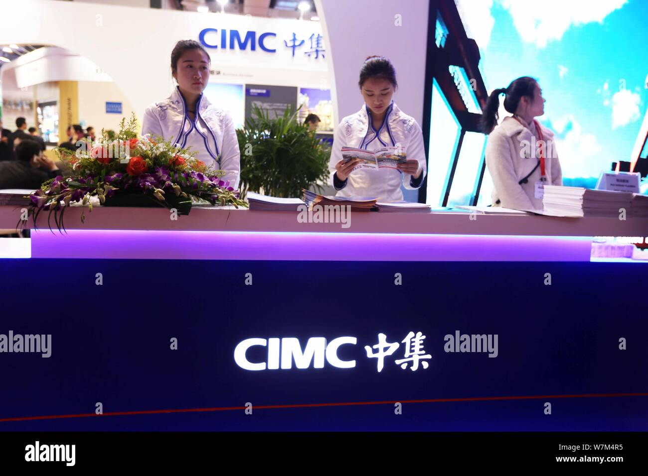 --FILE--Chinese employees are seen at the stand of CIMC (China ...