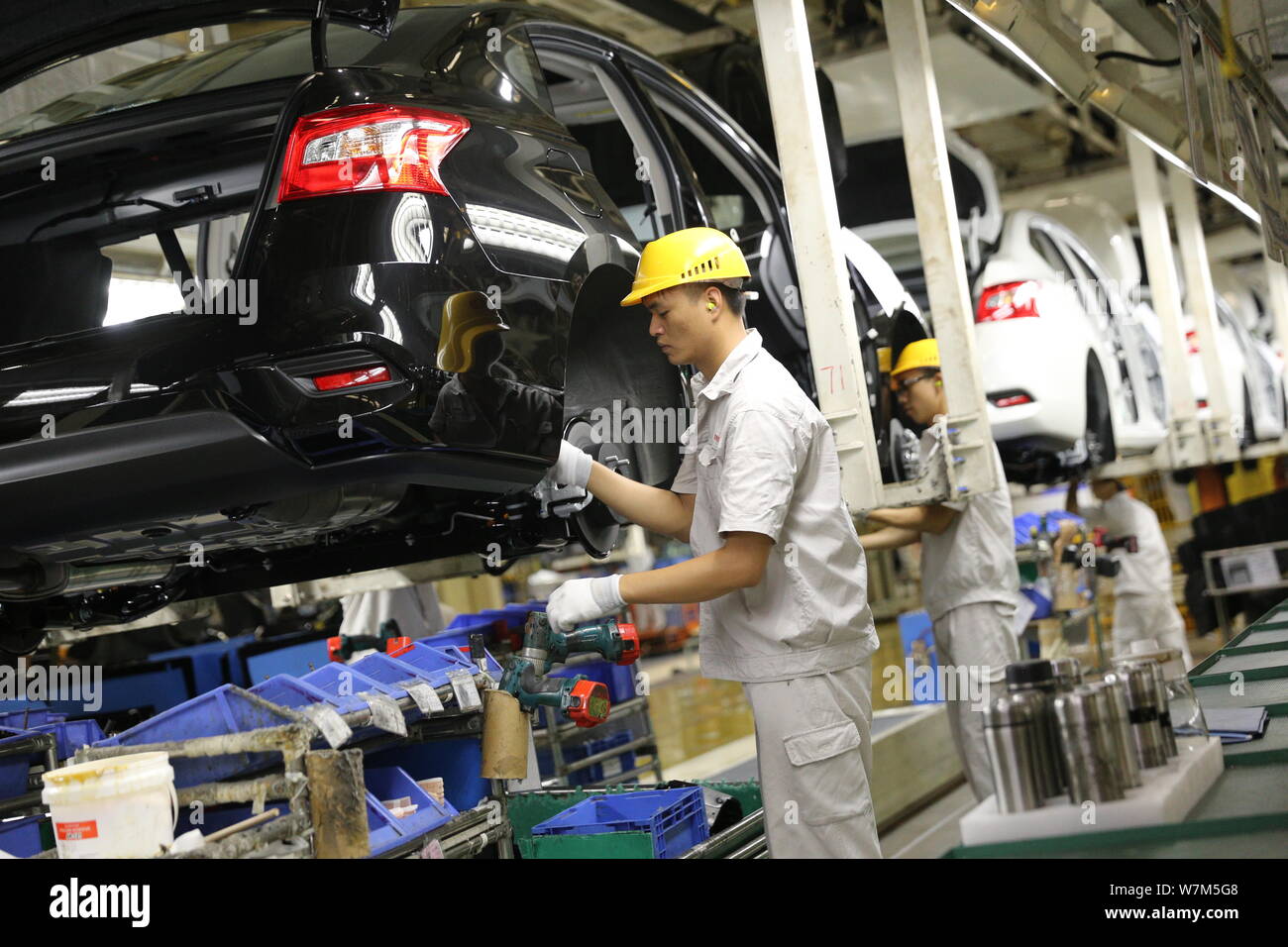--FILE--Chinese workers assemble cars on the assembly line at an auto ...
