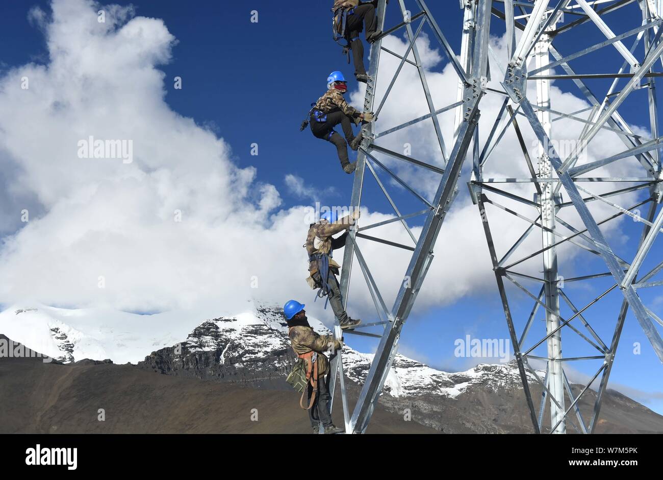 Electricity workers are assembling the highest power transmission tower in the world with a ...