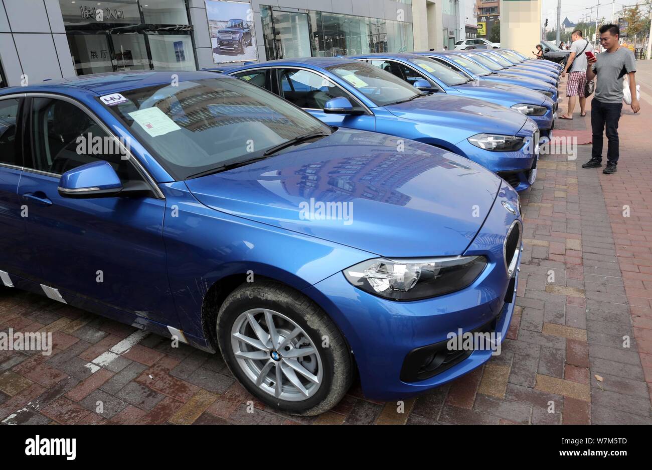A local resident uses his smartphone to scan a QR code via car-sharing ...