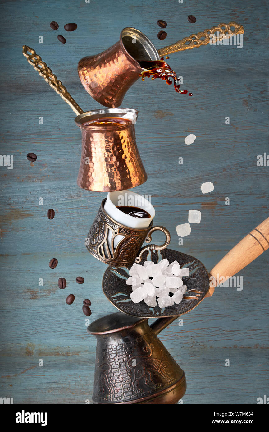Balancing pyramid of jezves, turkish coffee pots and cups on dark ...