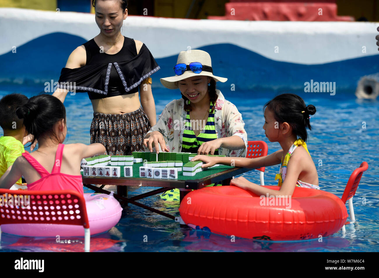 Chinese holidaymakers play mahjong in the water at a water park in ...