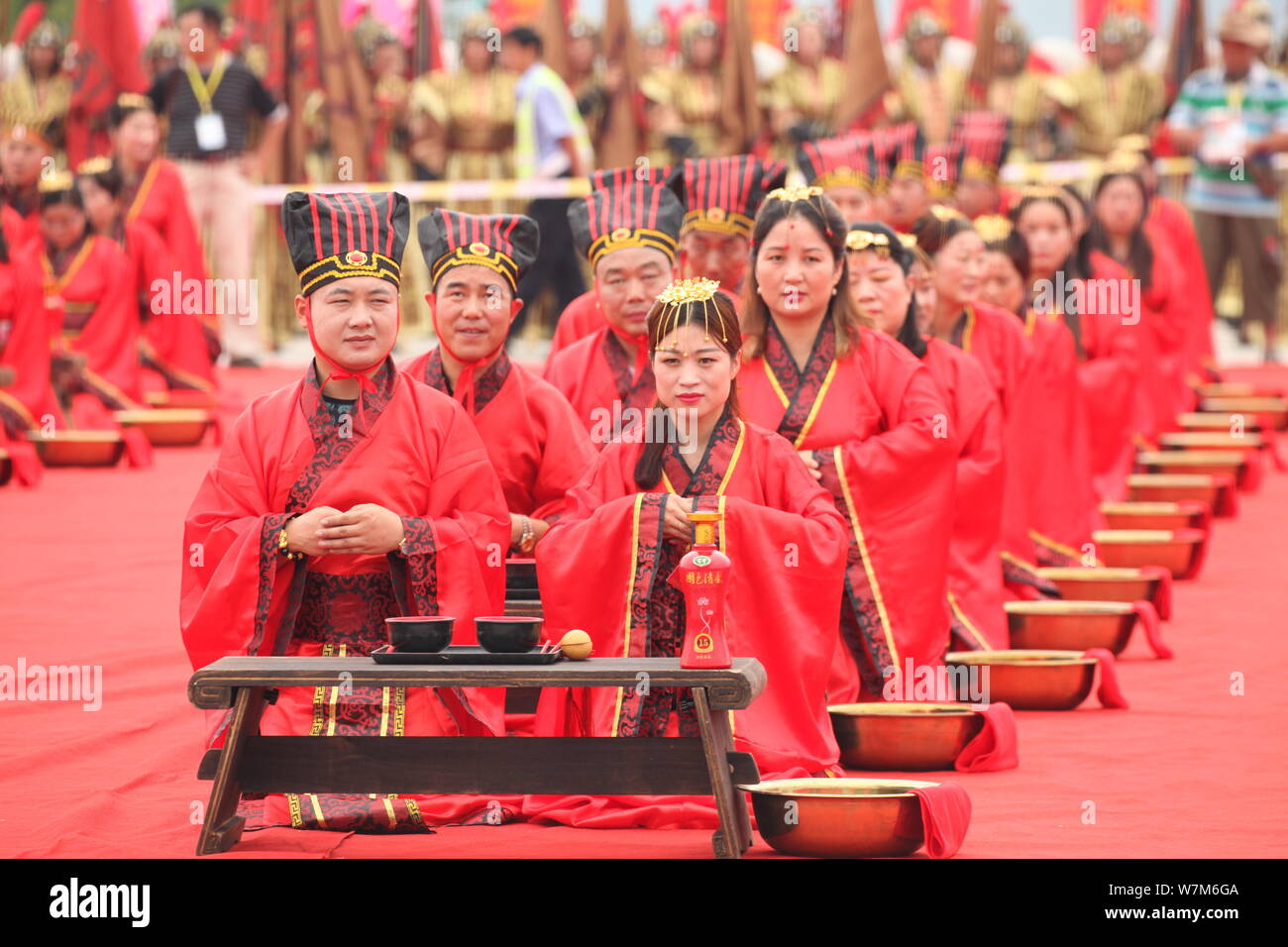 Couples of newlyweds dressed in traditional Han costumes take part in a ...