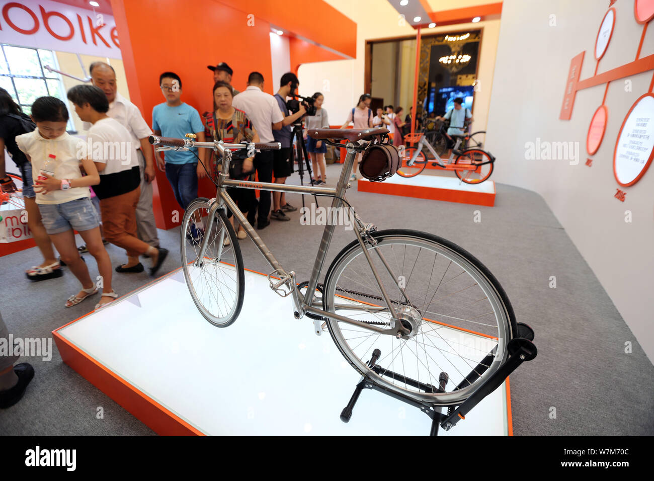 Visitors look at a 700c titanium alloy road bicycle of of Chinese bike ...