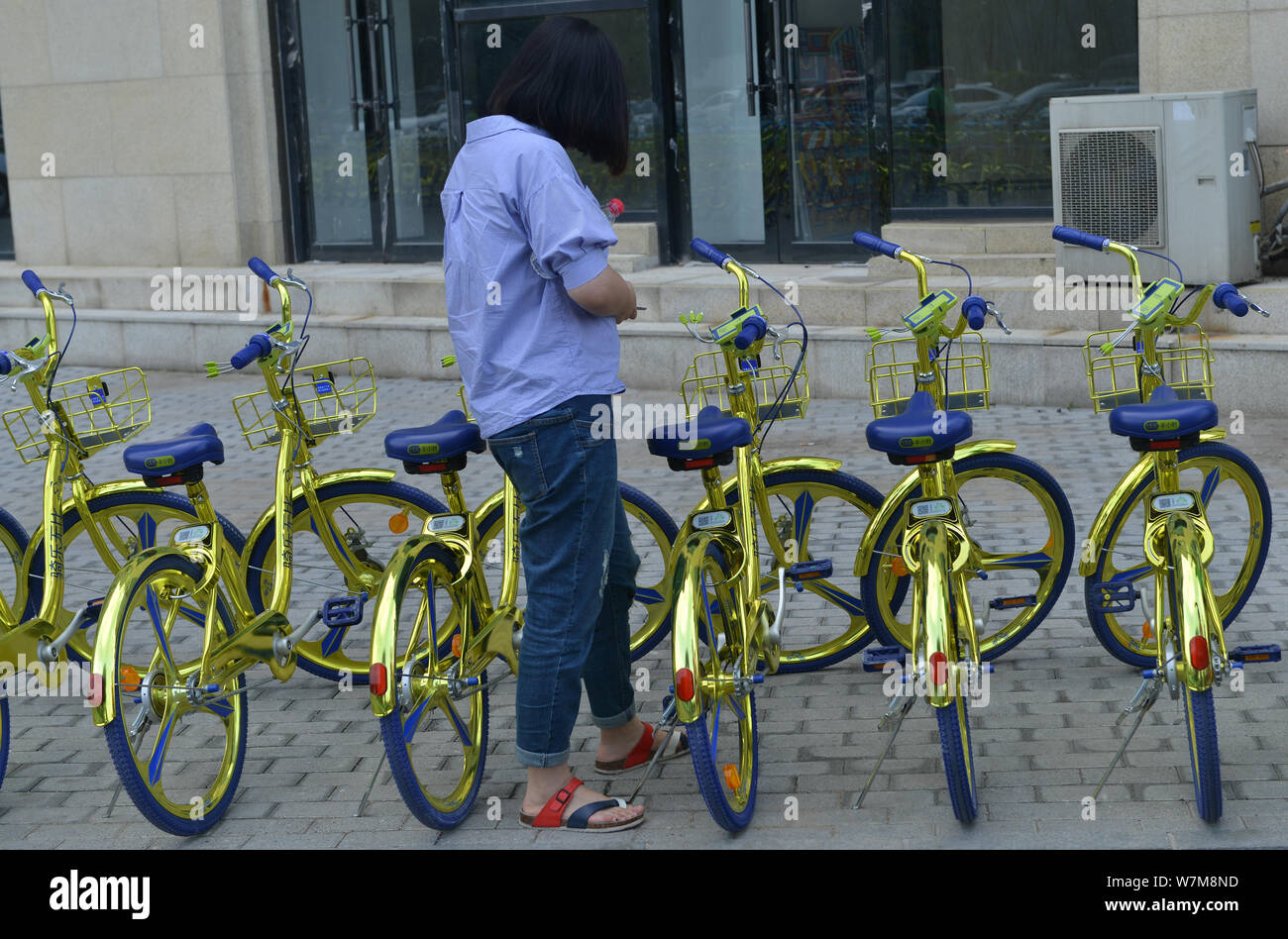 A local resident uses her smartphone to scan a QR code on a golden ...