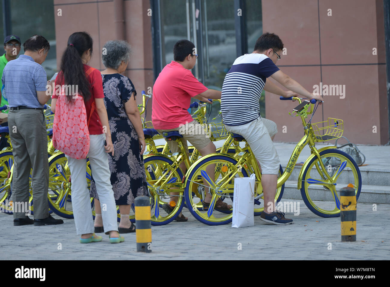 Local residents use their smartphones to scan QR codes on golden ...