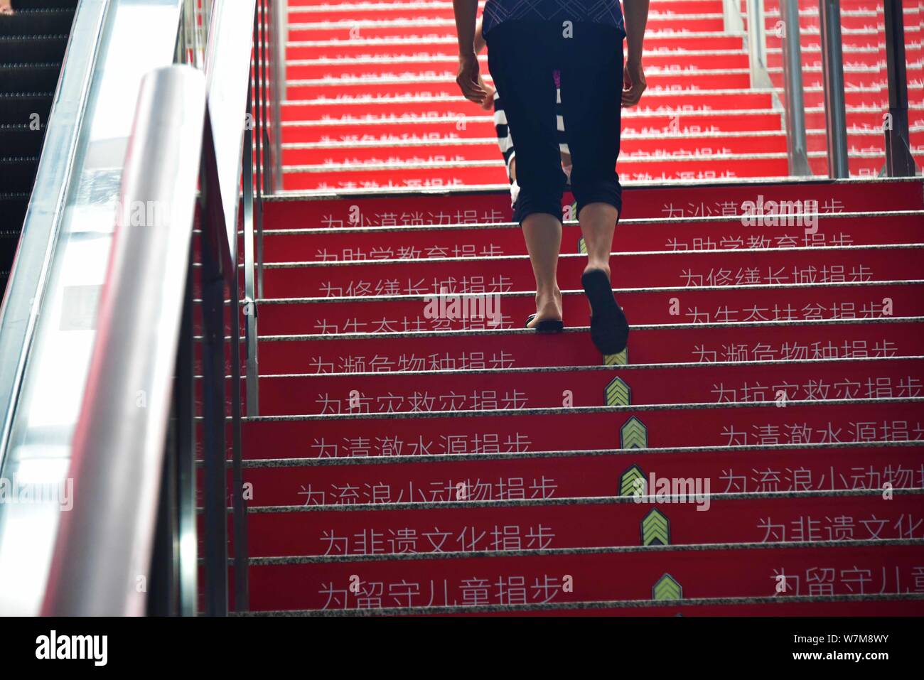 A passenger climbs stairs installed with infrared ray detectors to ...