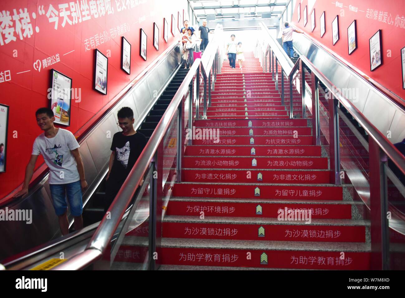 Passengers walk on stairs installed with infrared ray detectors to ...