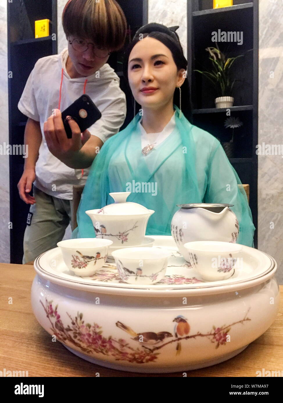 A customer takes selfies with a wax figure of Chinese actress Yang Mi ...