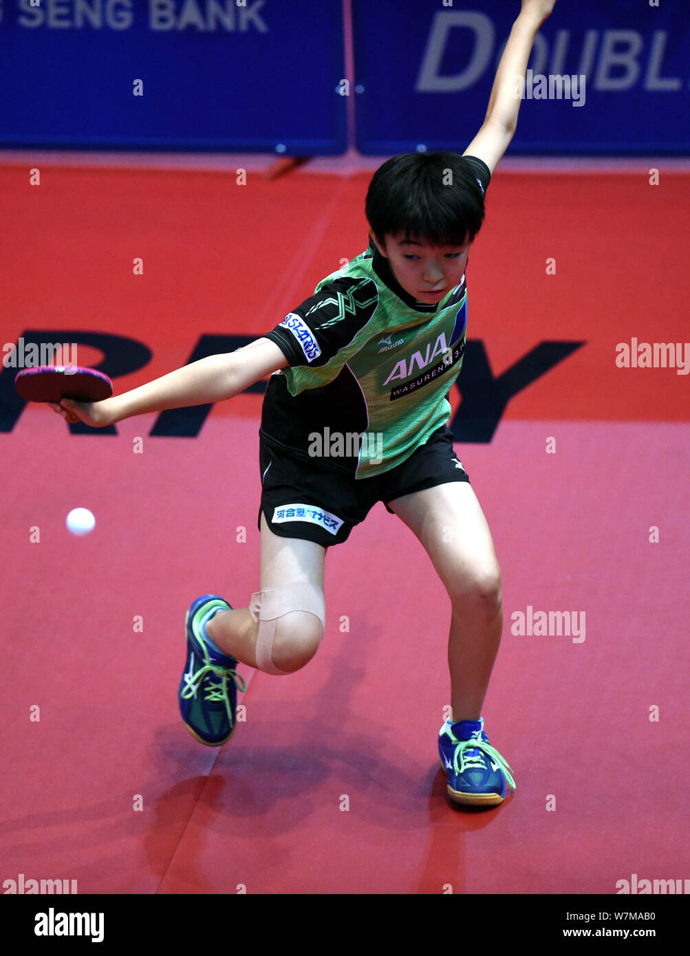 Ojio Haruna of Japan returns a shot as she and Yumoto Fuwa compete against Ng Wing Lam and Lee ...