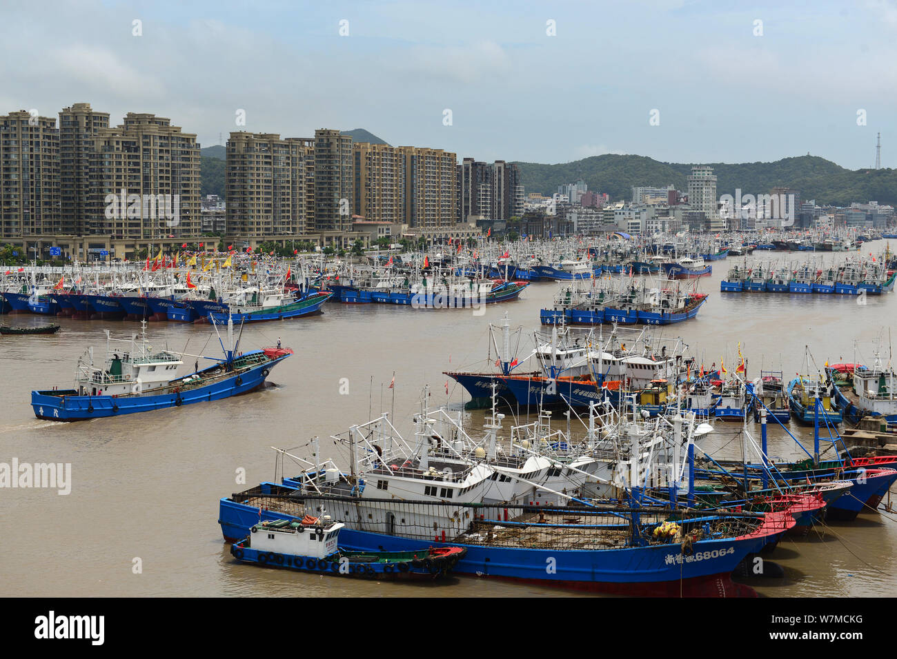 Fishing boats are docked at a harbor in preparation for Typhoon Nesat ...