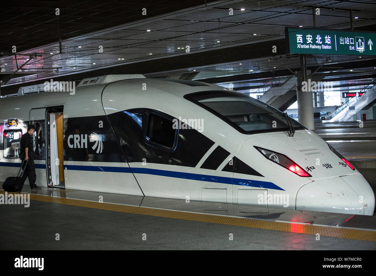 An employee boards a CRH5G (China Railway High-speed) bullet train at ...