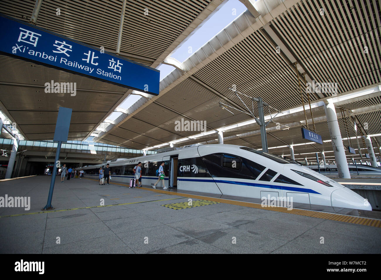Passengers board a CRH5G (China Railway High-speed) bullet train at the ...