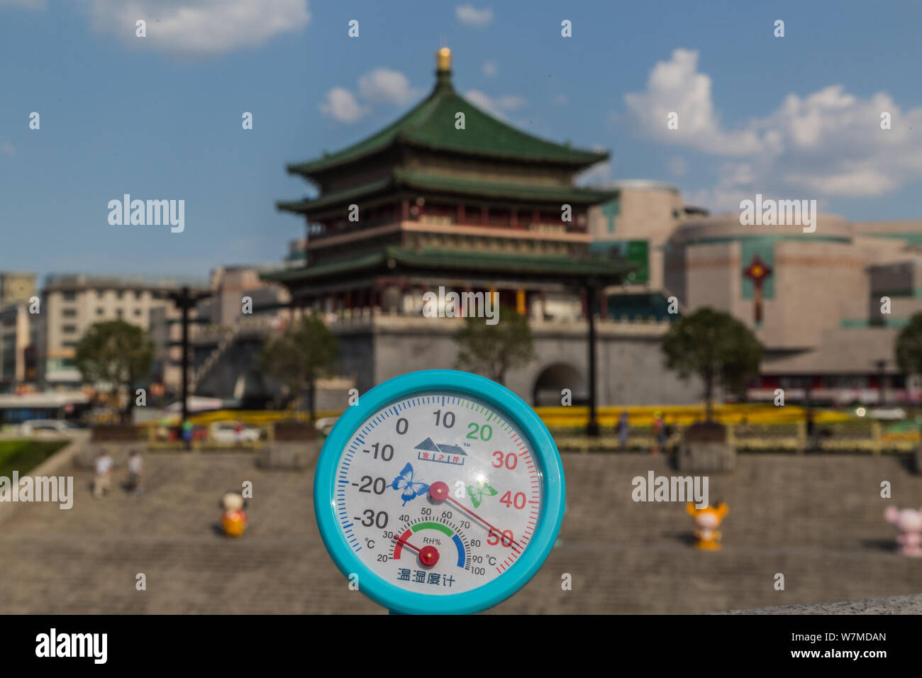 A local resident displays a thermometer showing the current temperature ...